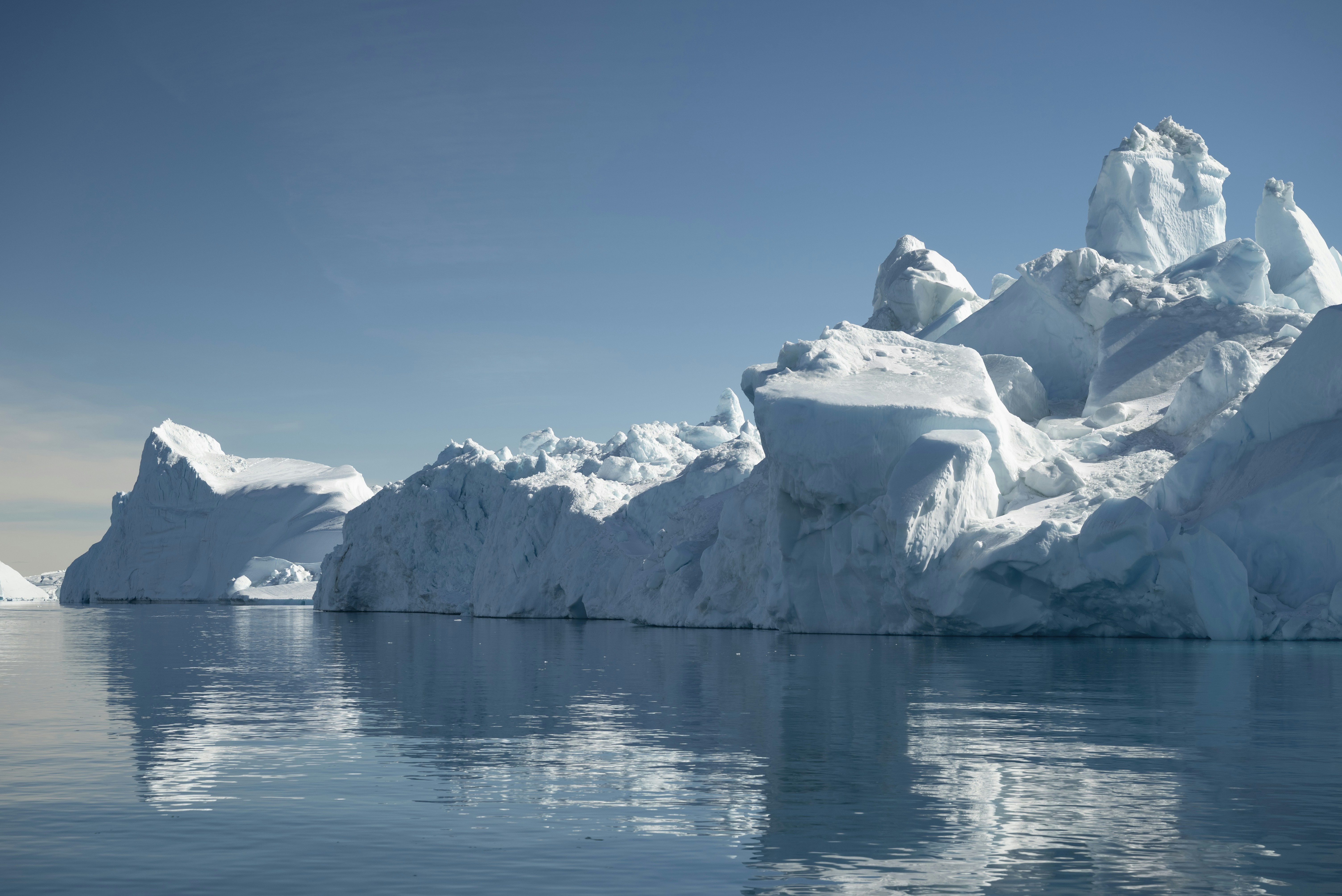 Glacial Sentinel: Towering Iceberg Against a Calm Arctic Sea
