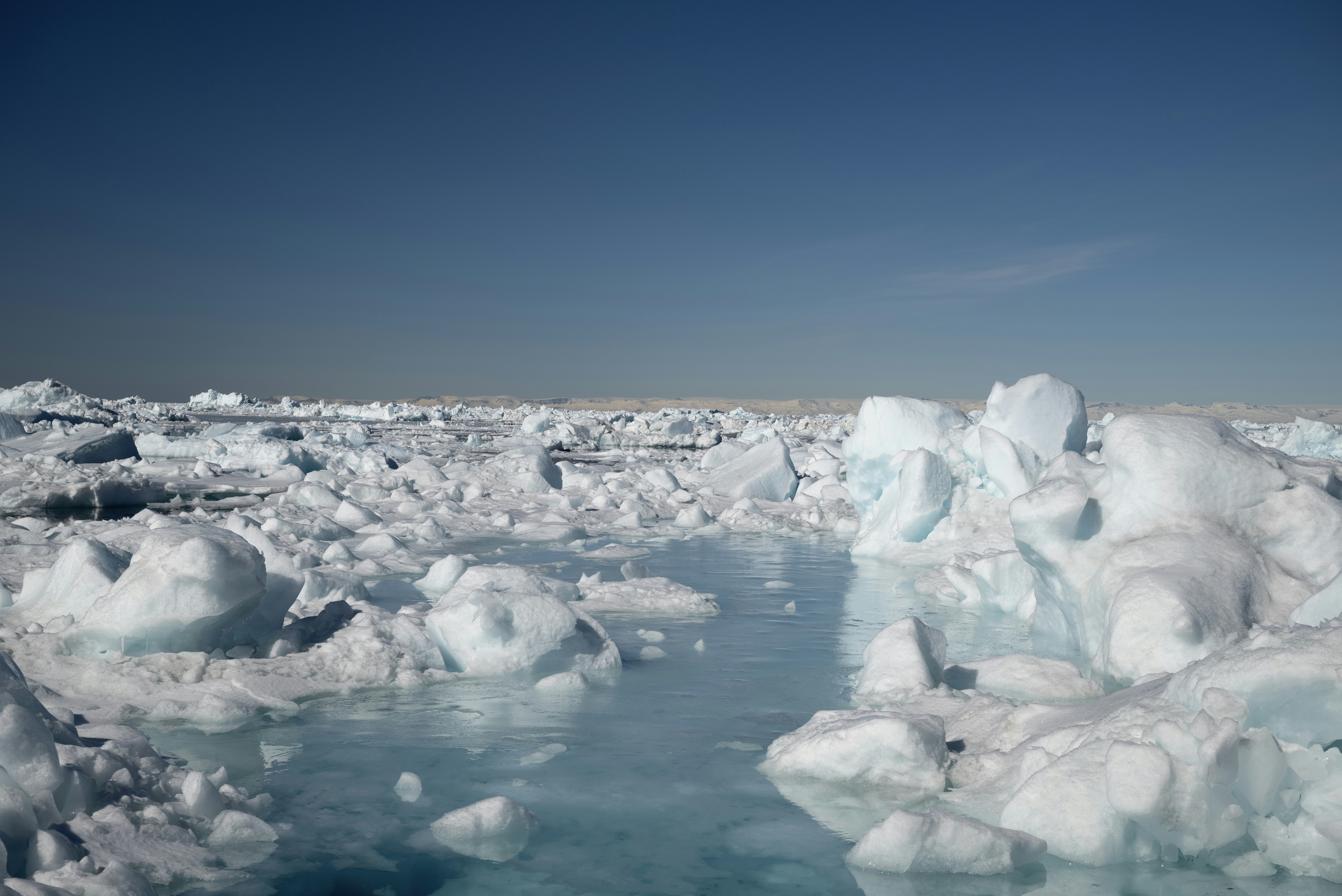 Midday Icefield: Jagged Ice Floes under a Clear Arctic Sky
