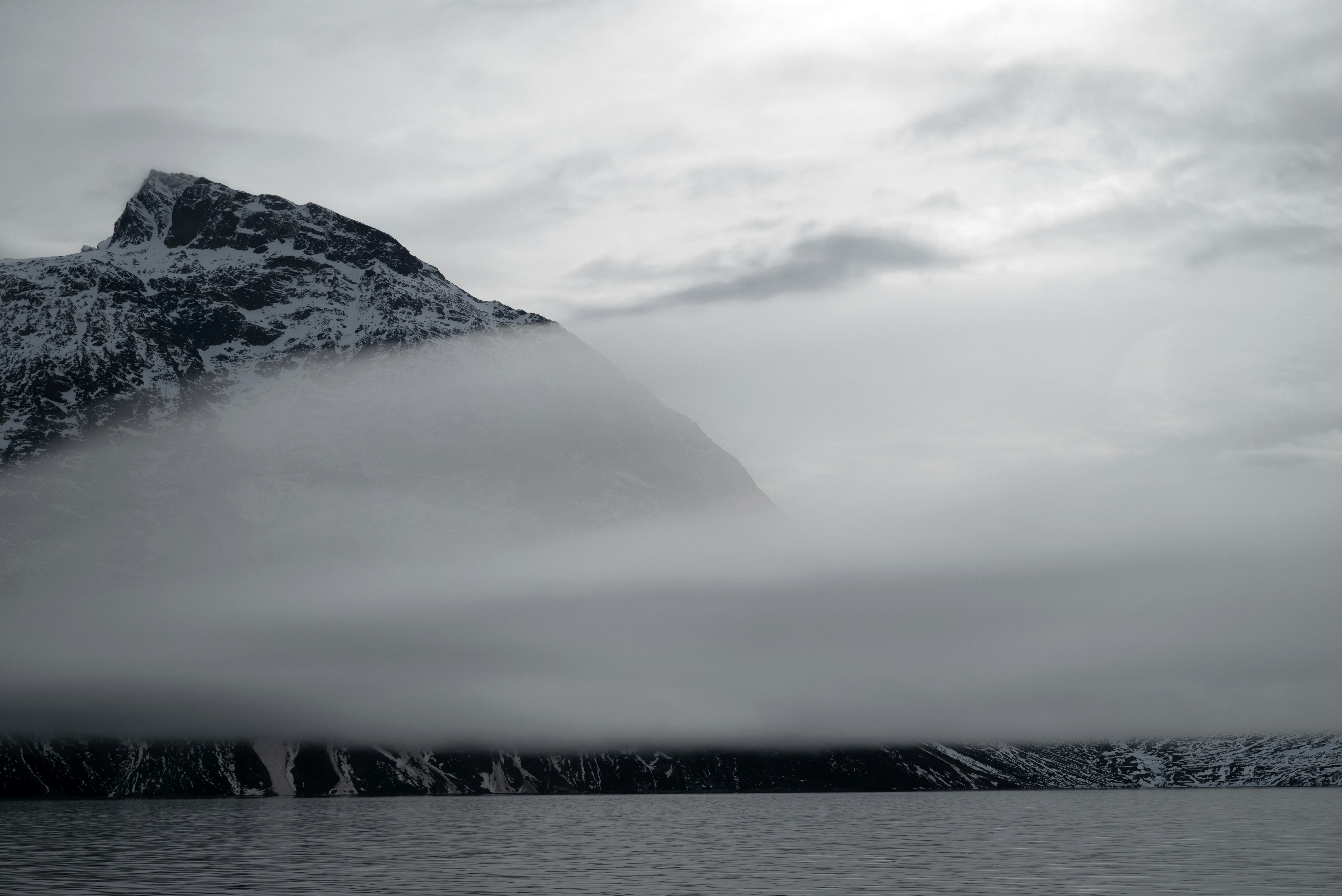 Emerald Peak Emerges Through Silent Fjord Mist