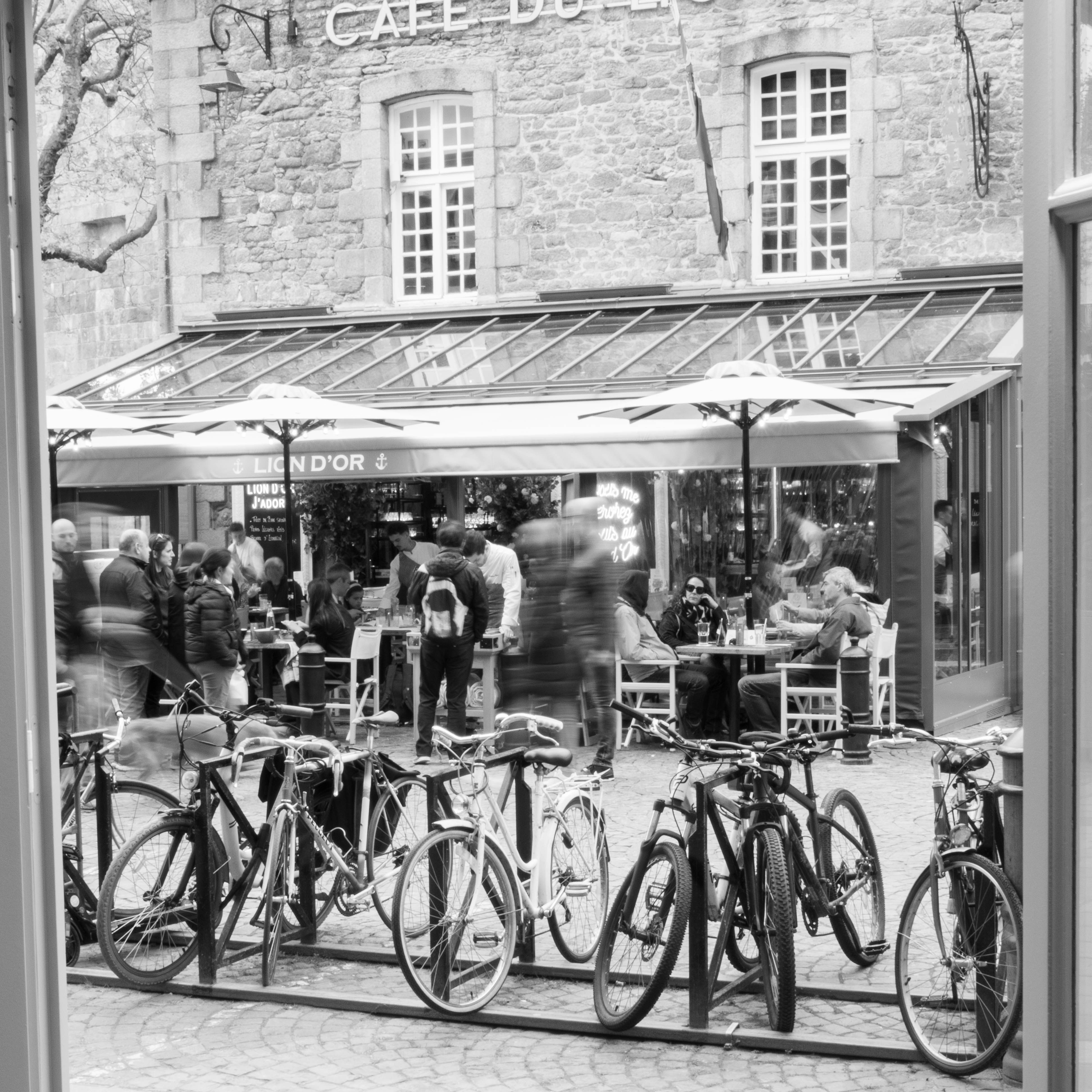 Cafe Terrace Through the Glass: Bicycles and Bottled Moments