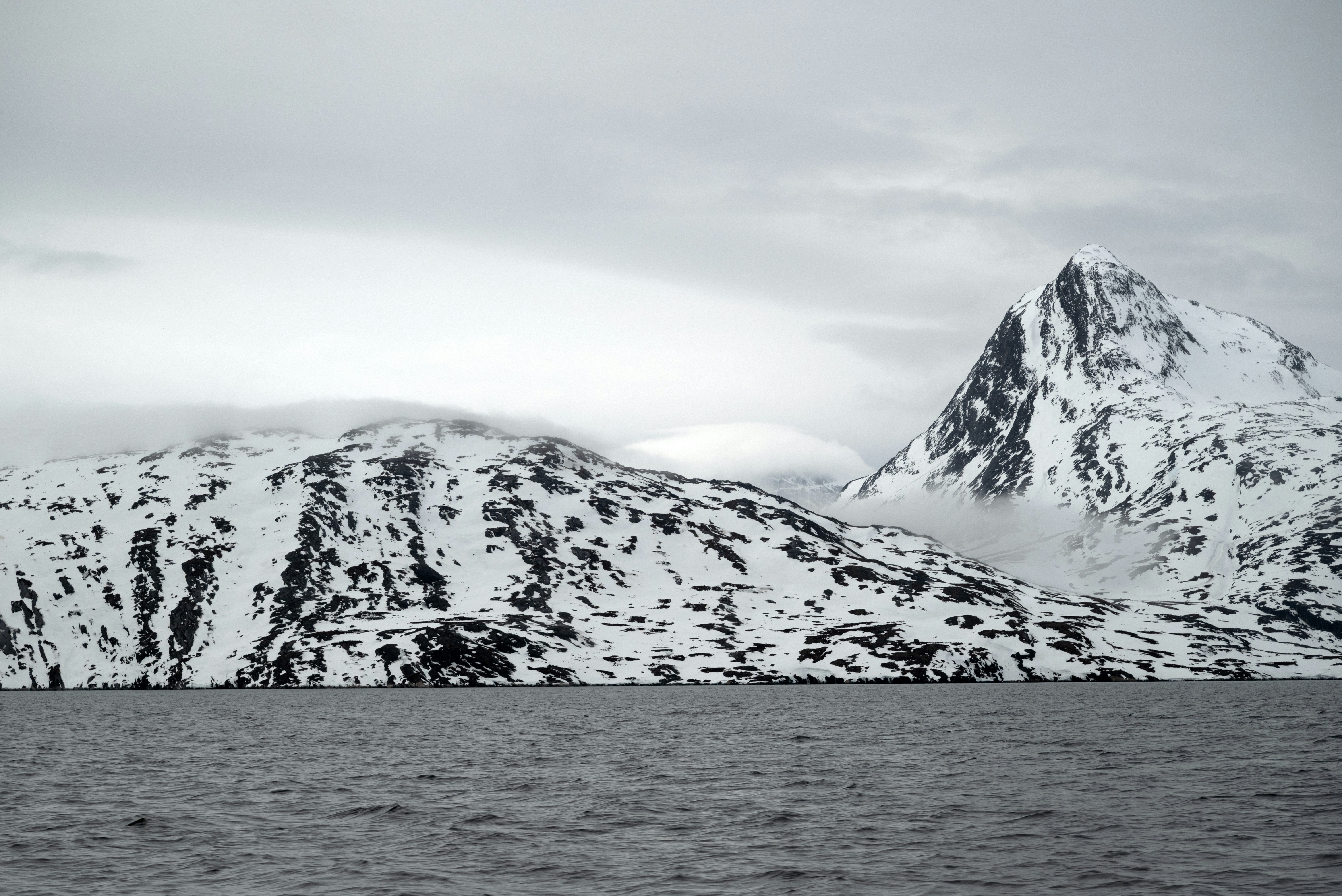 Snowbound Summit over a Windswept Sea