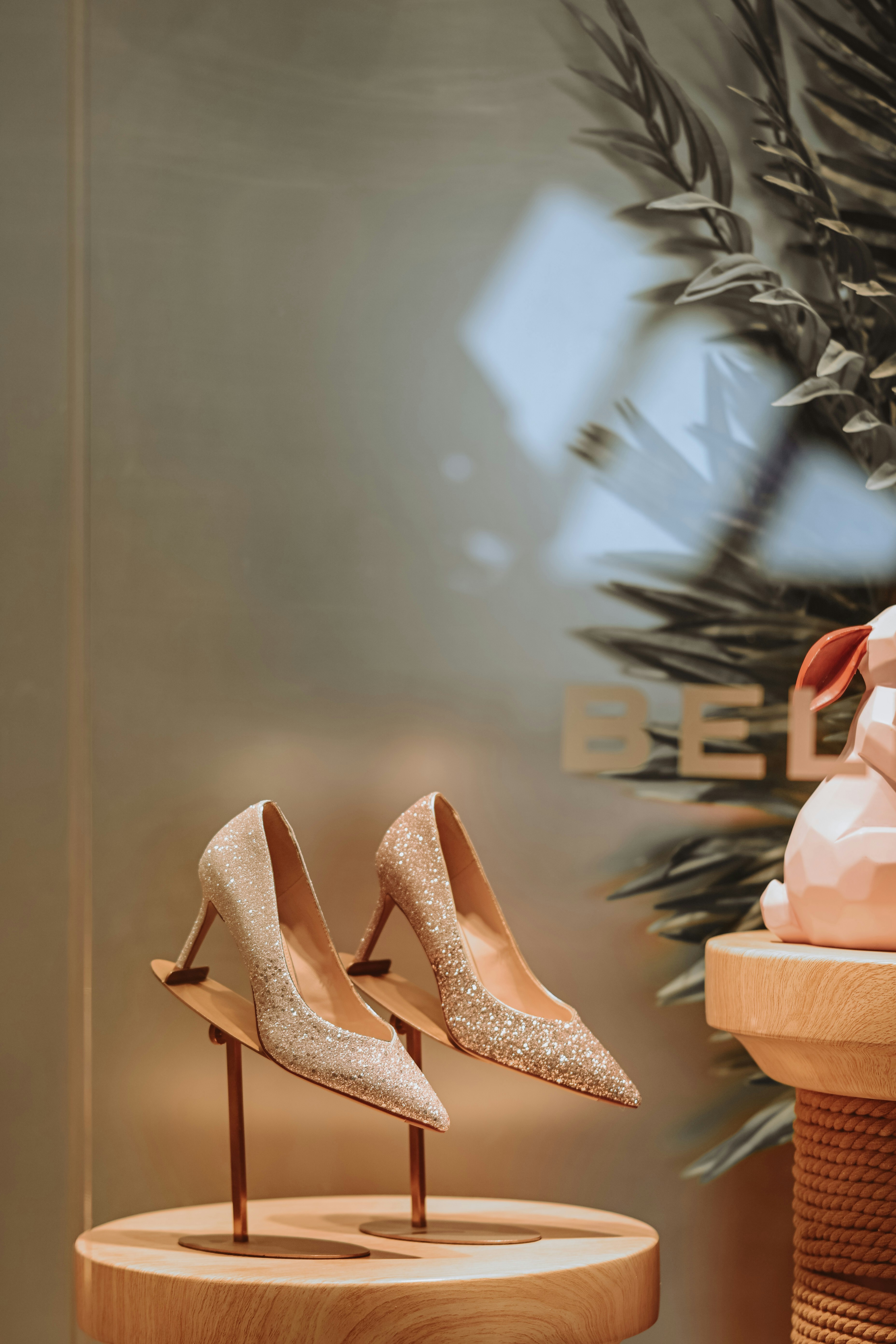 Glittering heels on a wooden pedestal in a boutique window