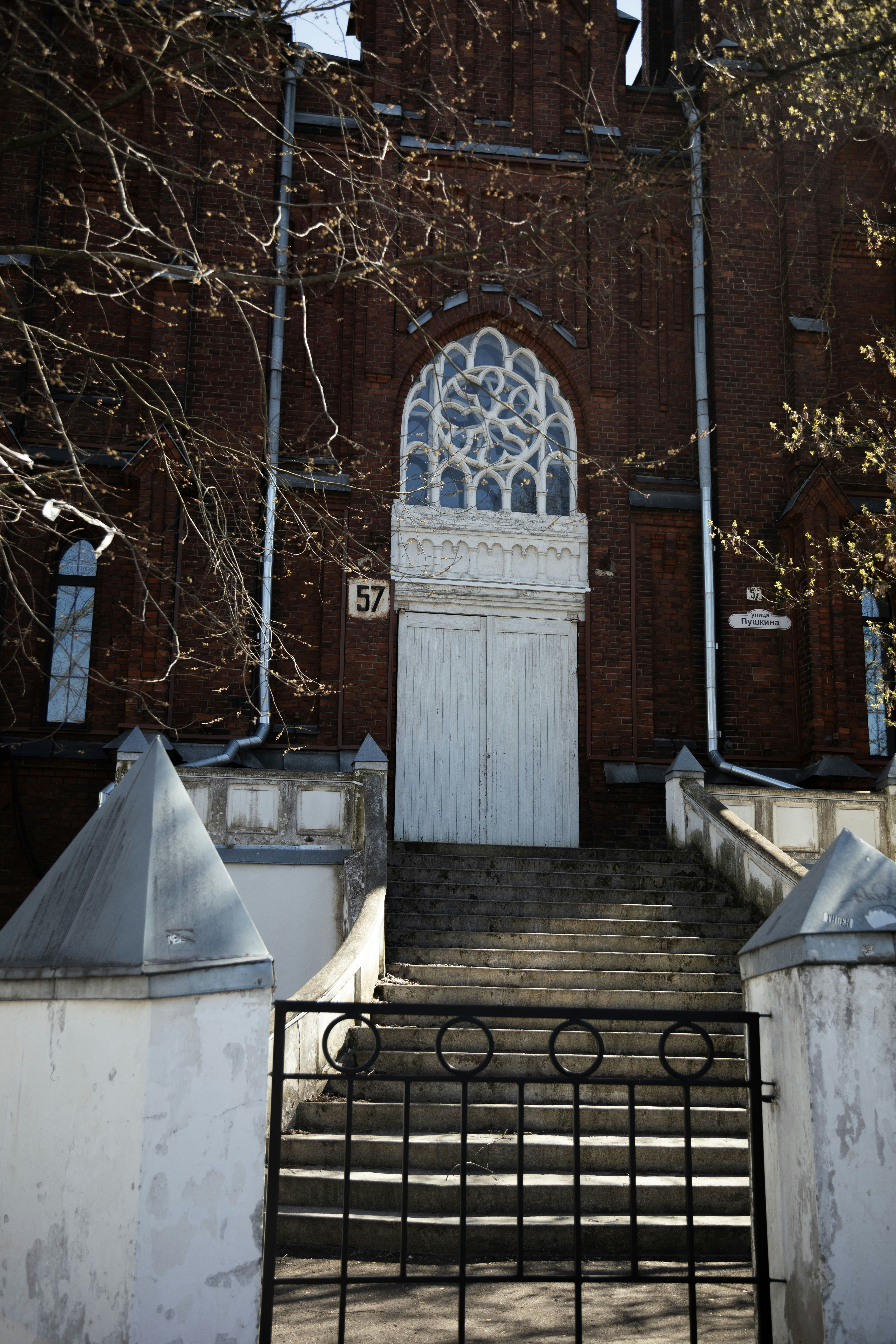Stairway to a White-arched Entrance Across a Red Brick Facade