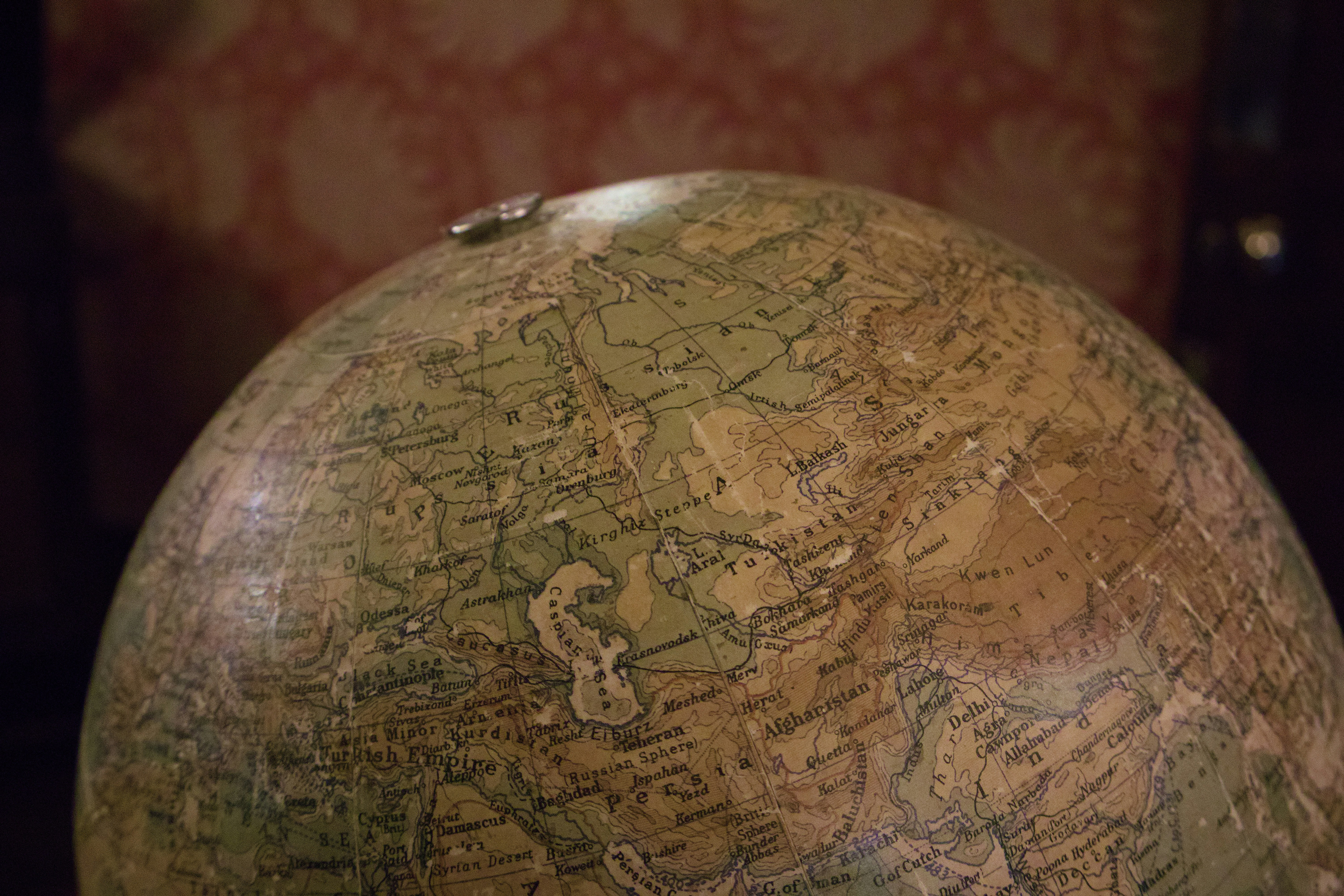 Aged Atlas: detail of a worn globe under warm lamplight