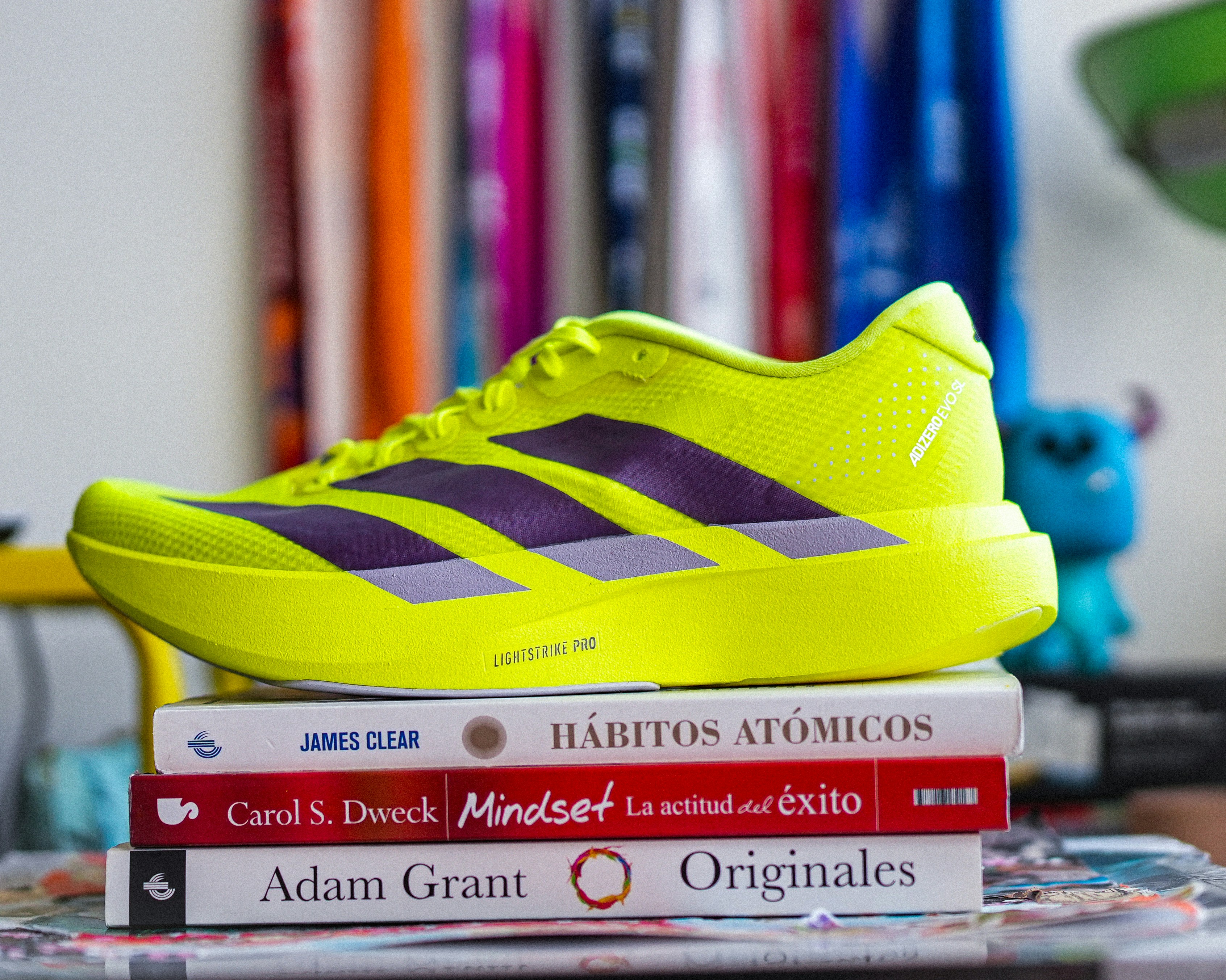 Neon sprint: a bright running shoe balancing atop a stack of books
