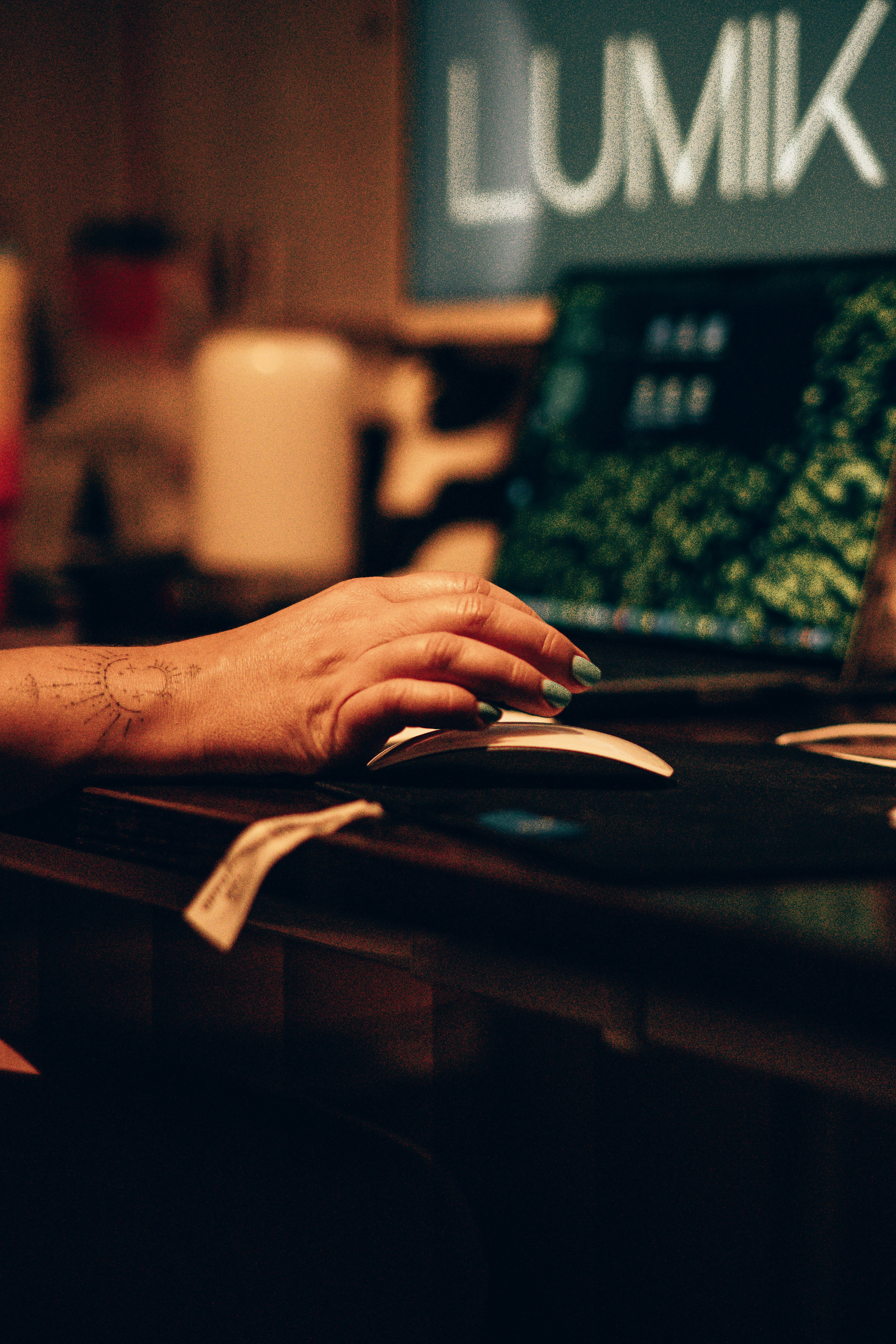 Hand on a Quiet Screen: Neon Glow and Focus in a Laptop Bar