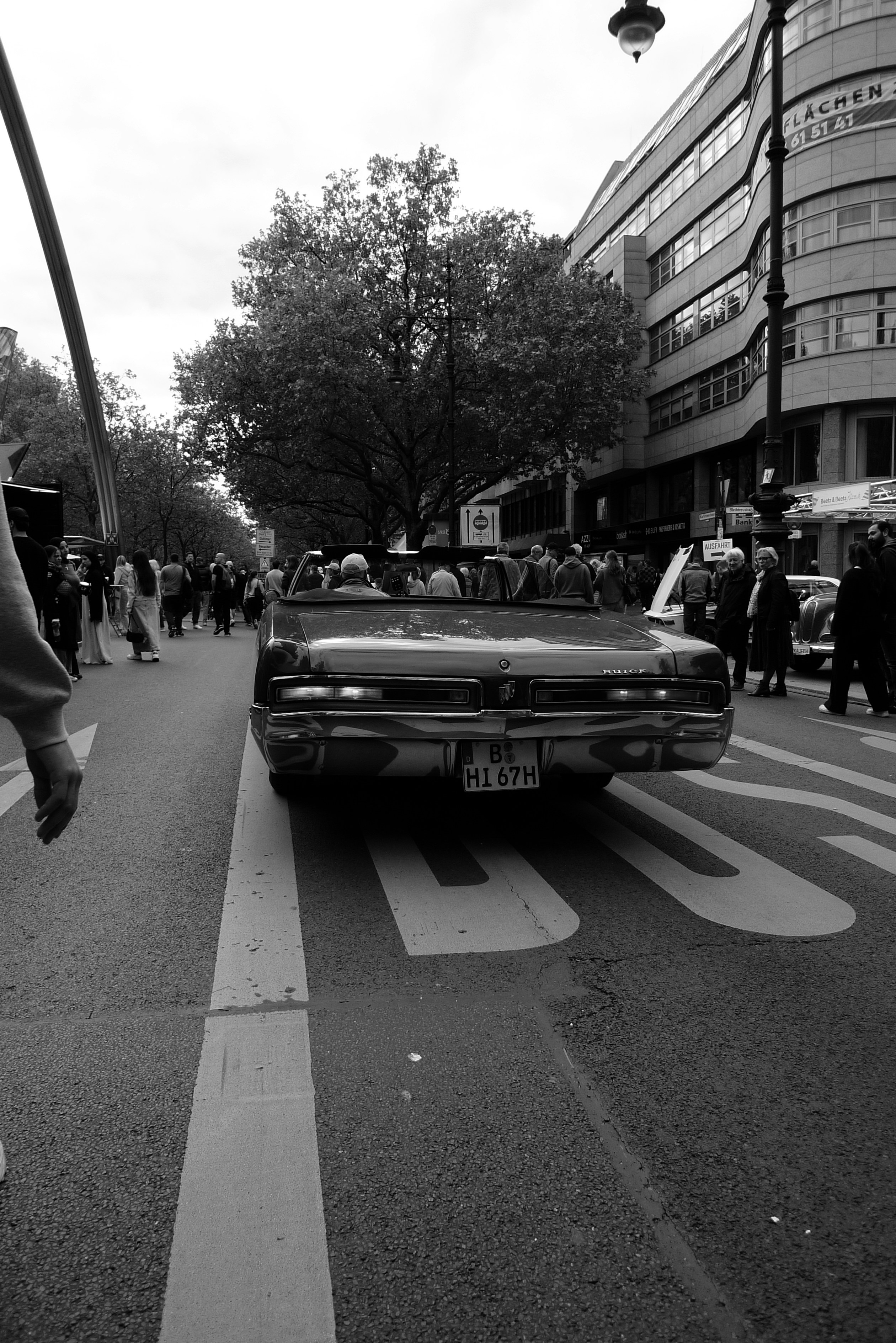 A Classic Convertible Halt Amid a City Parade