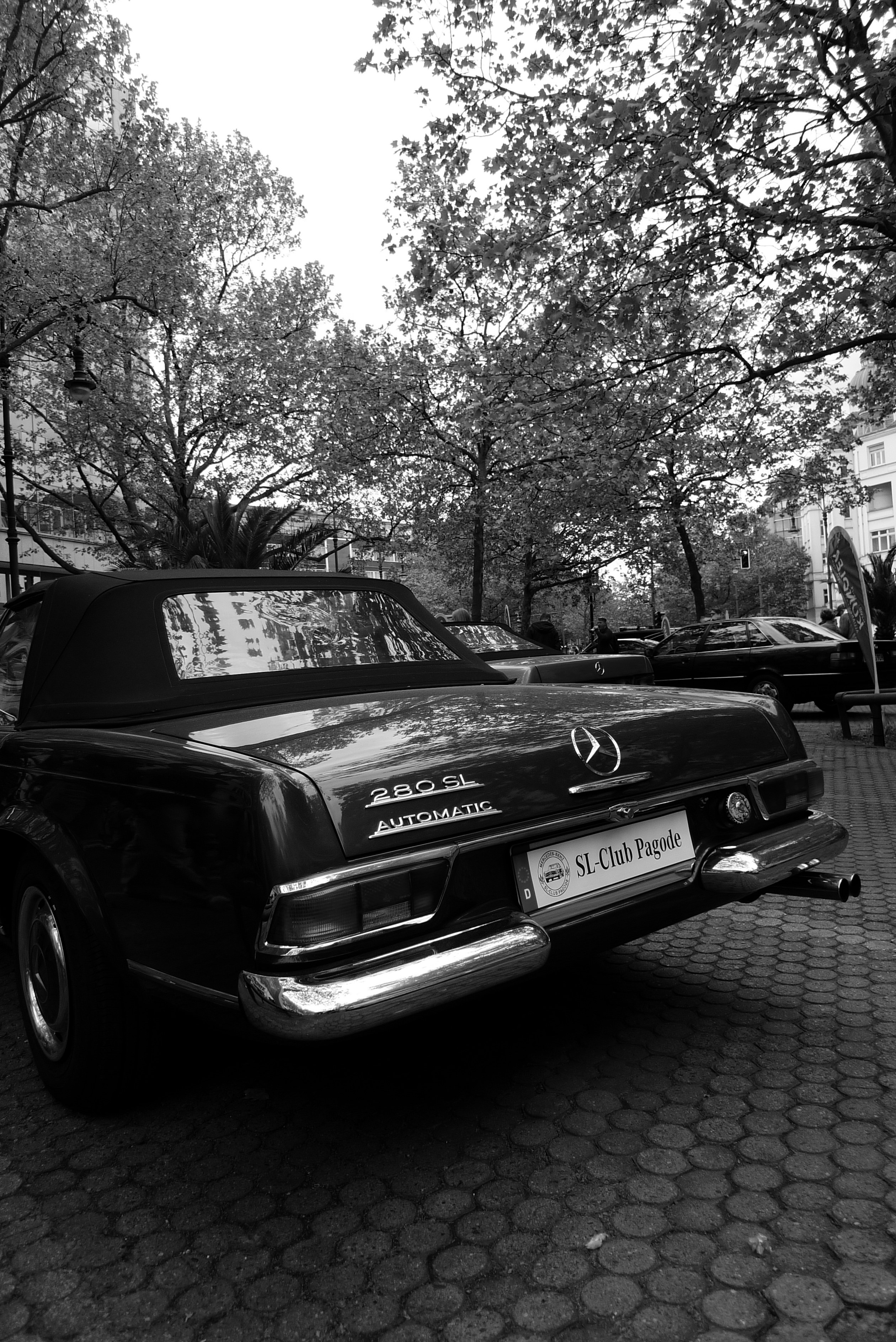 Rearview of a classic Mercedes: chrome, curves, and cobblestones