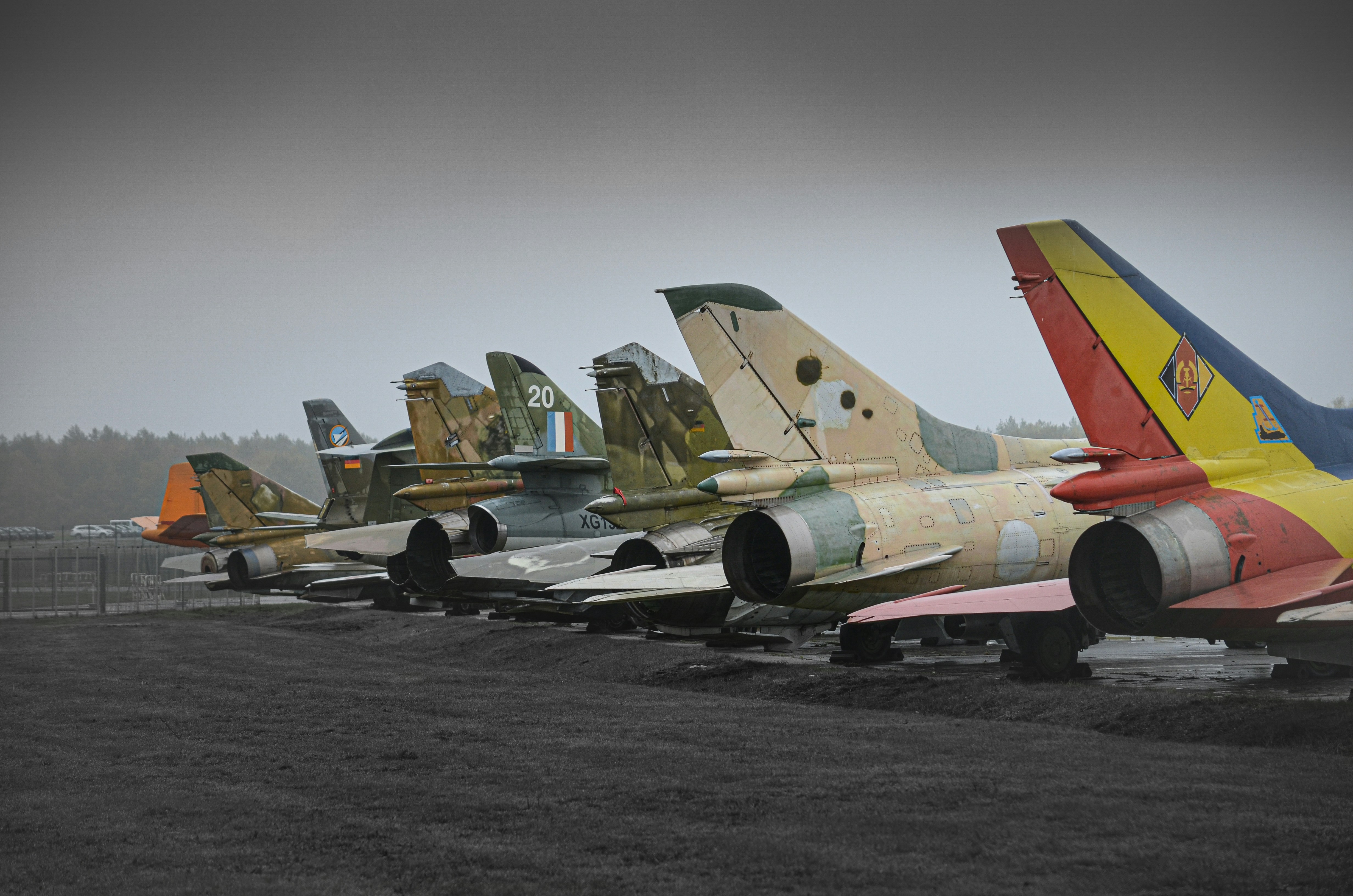 Row of sun-bleached jet trainers resting in a quiet airfield