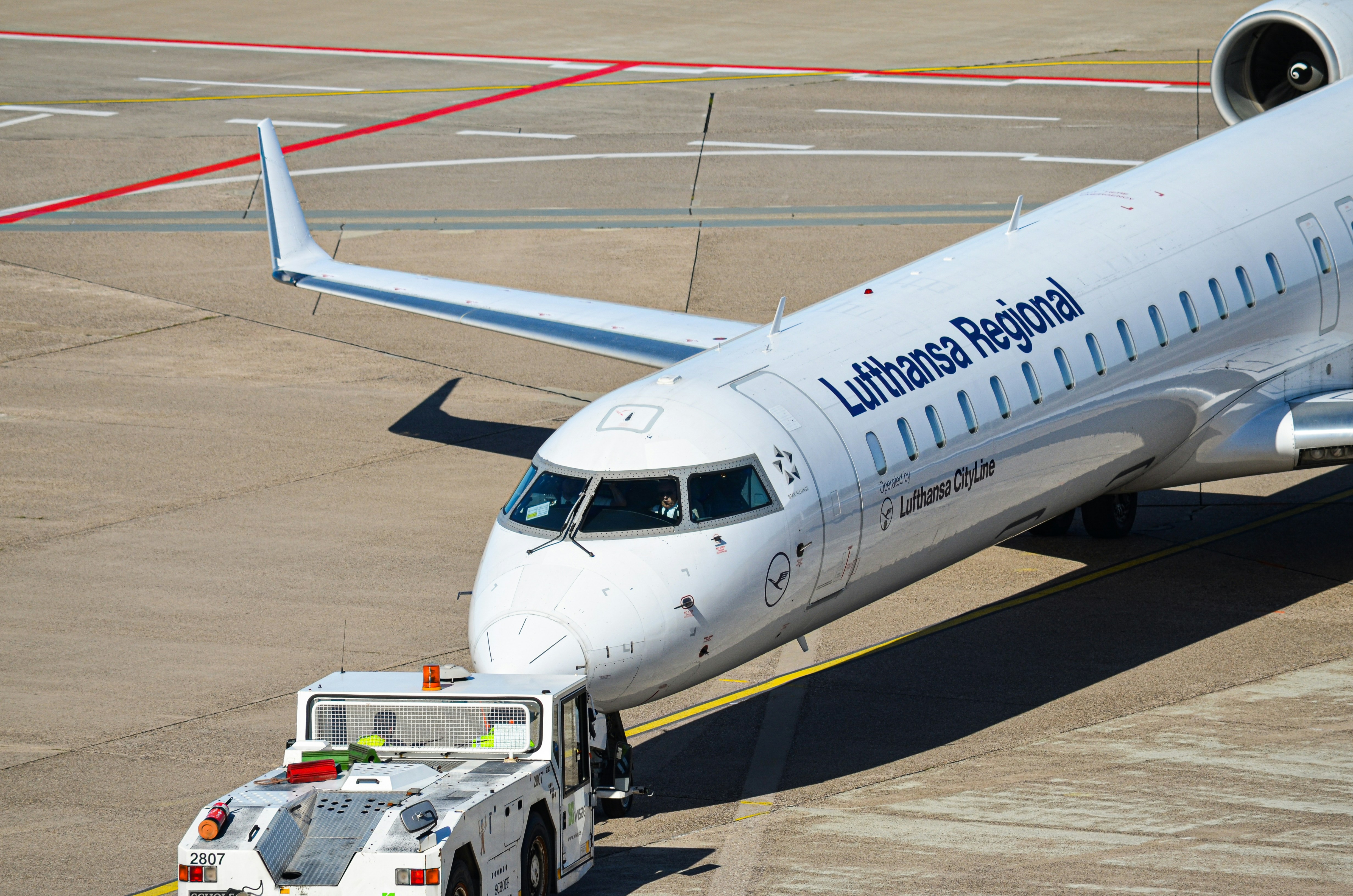 Ground Crew Pushes Lufthansa Regional Jet Toward Gate