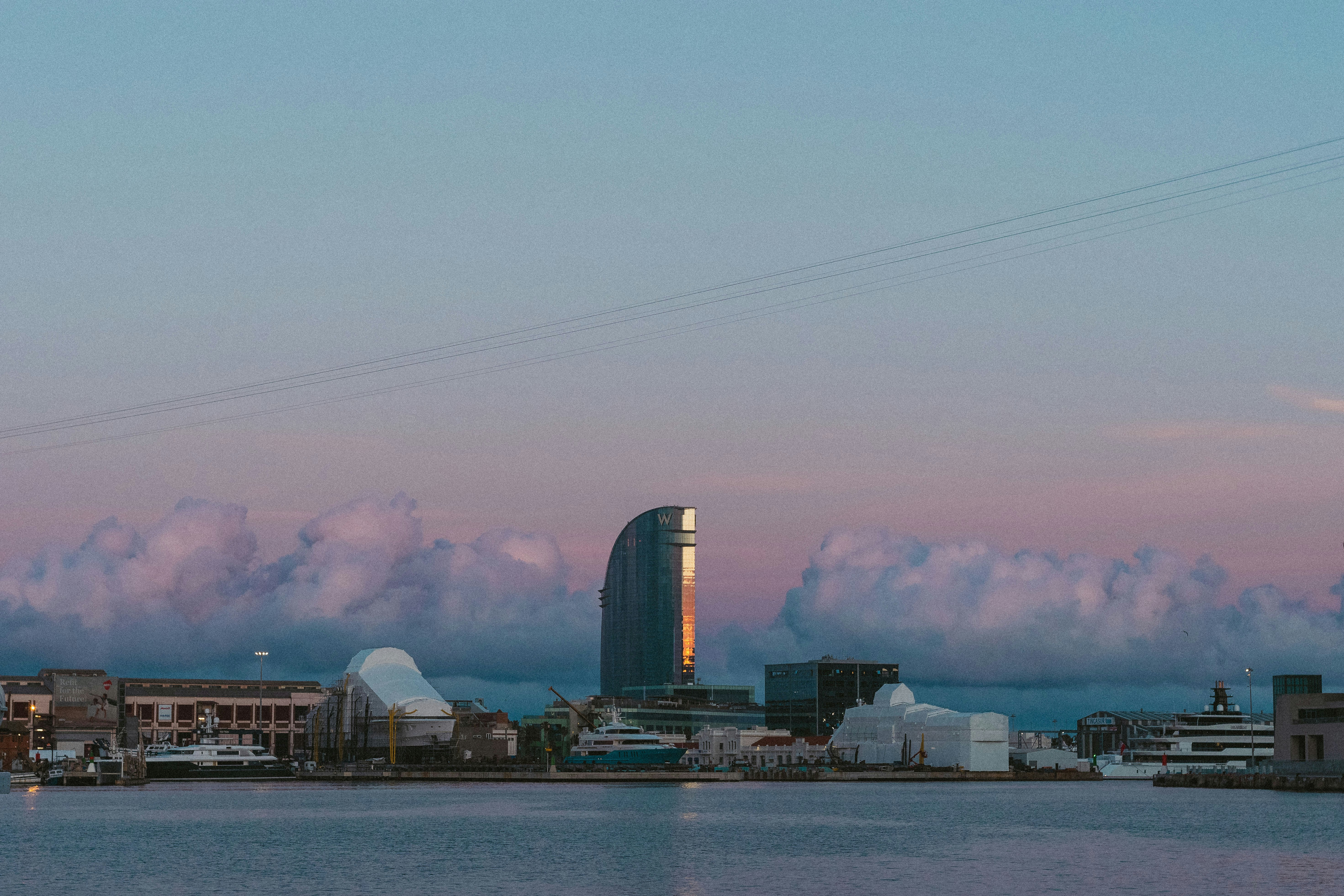Dusk Over the Harbor: The Tall, Glassy Beacon