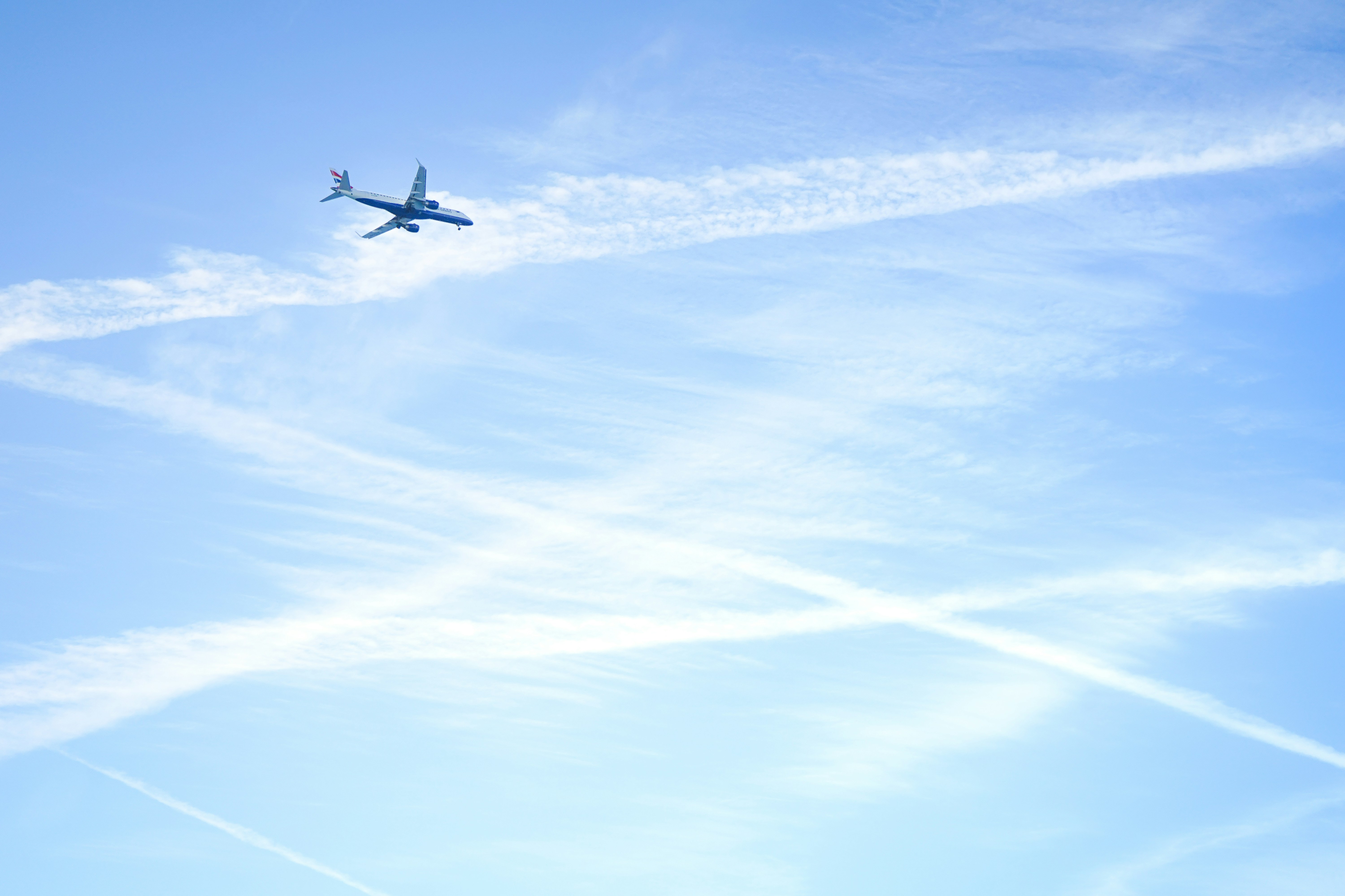 High Flight: An Airliner Traces a Quiet Path Across Cyan Skies