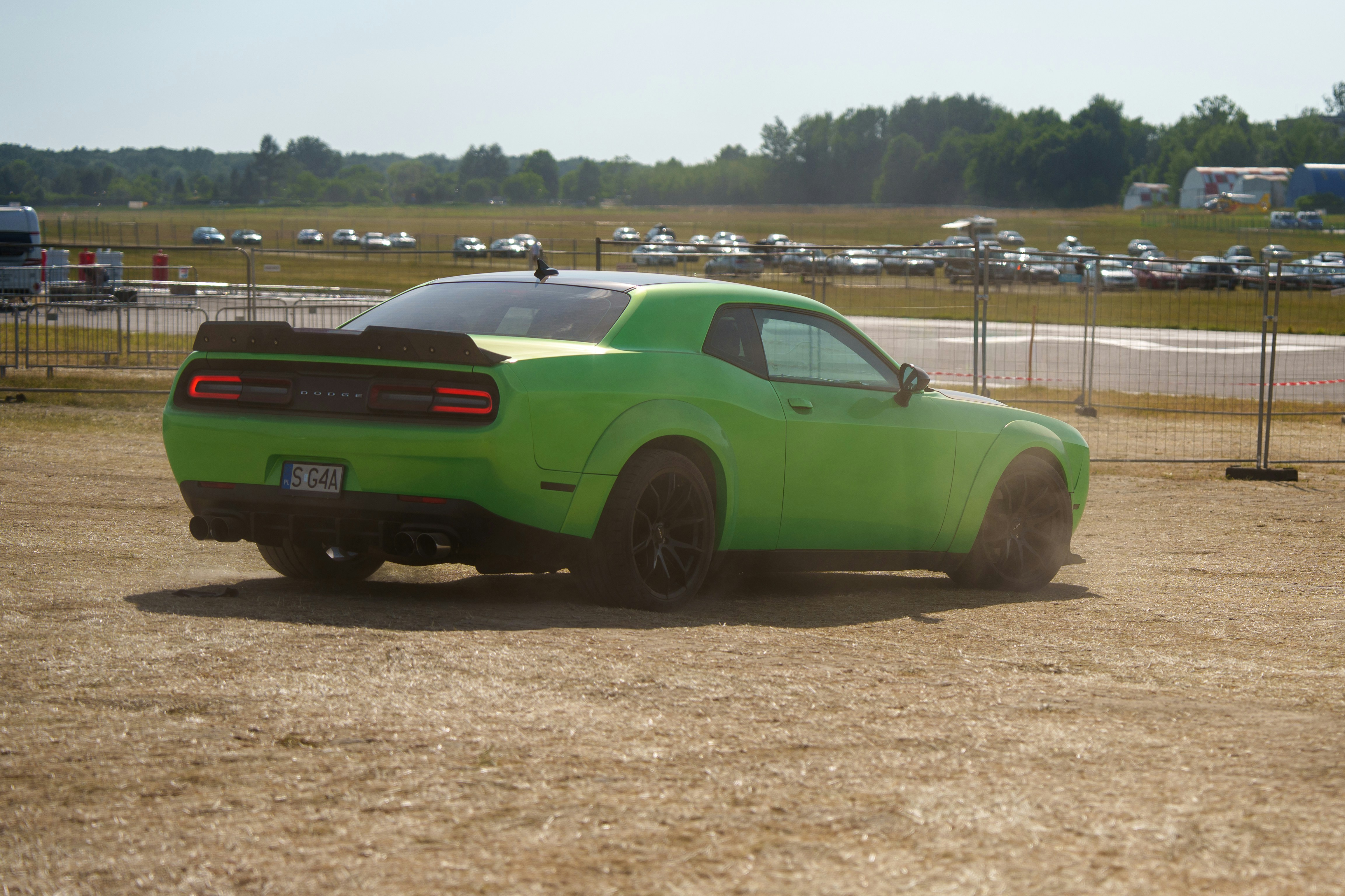 Neon-green muscle car on a dusty off-road field