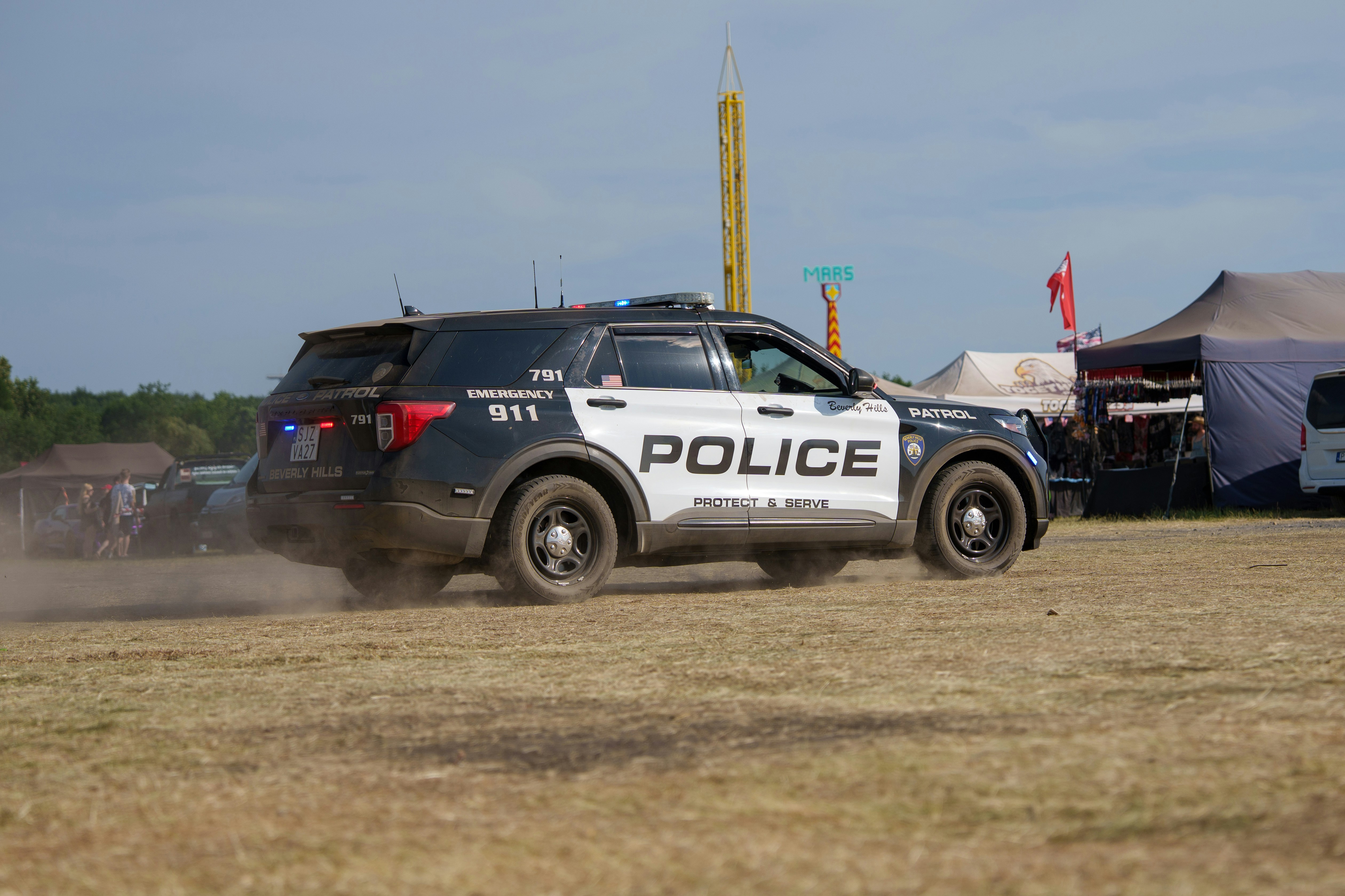 Speed and Sirens: Police SUV Roars Across a Dusty Field