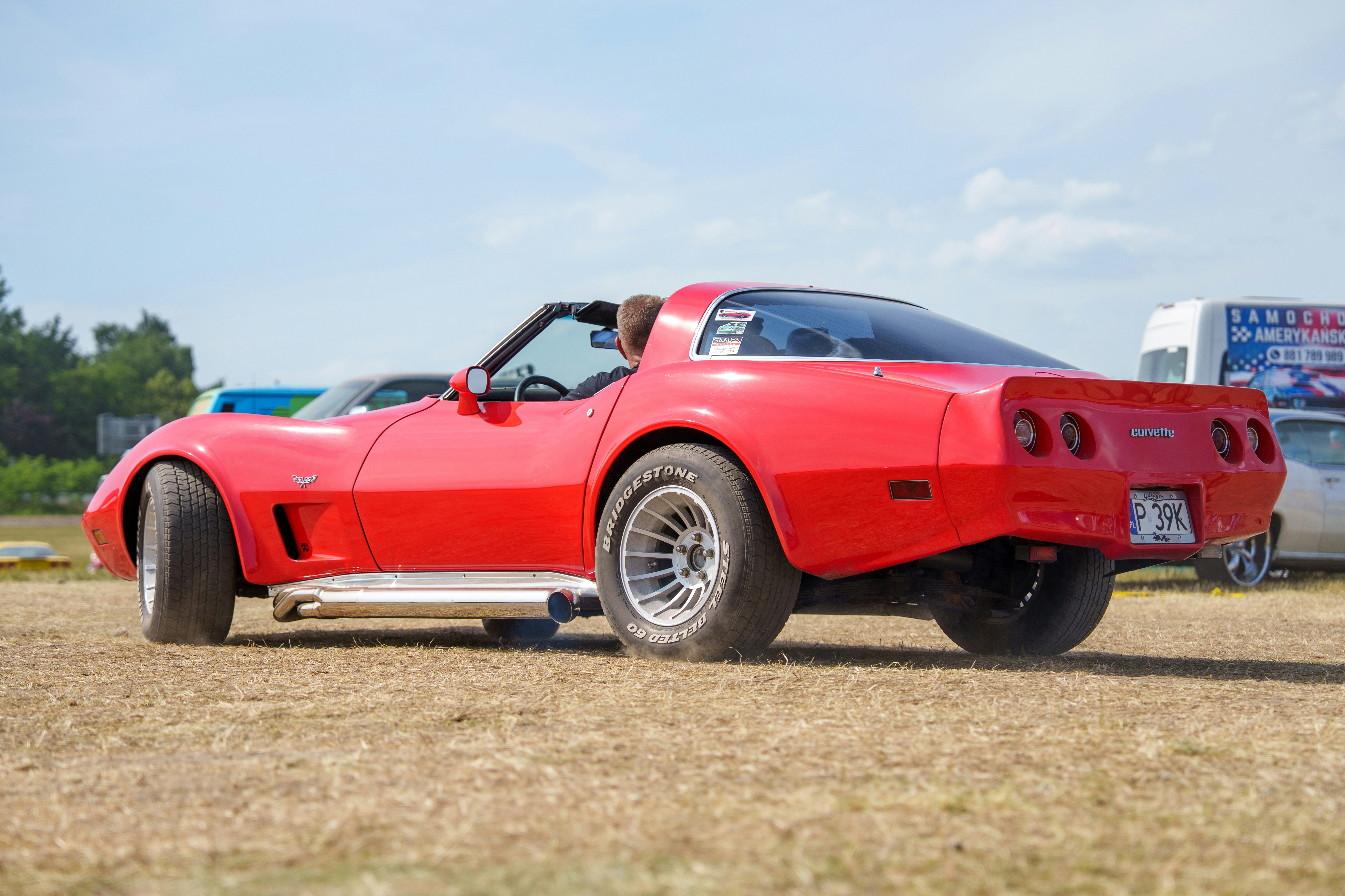 Red Roadster in Field: A Sunlit Stance at a Car Show