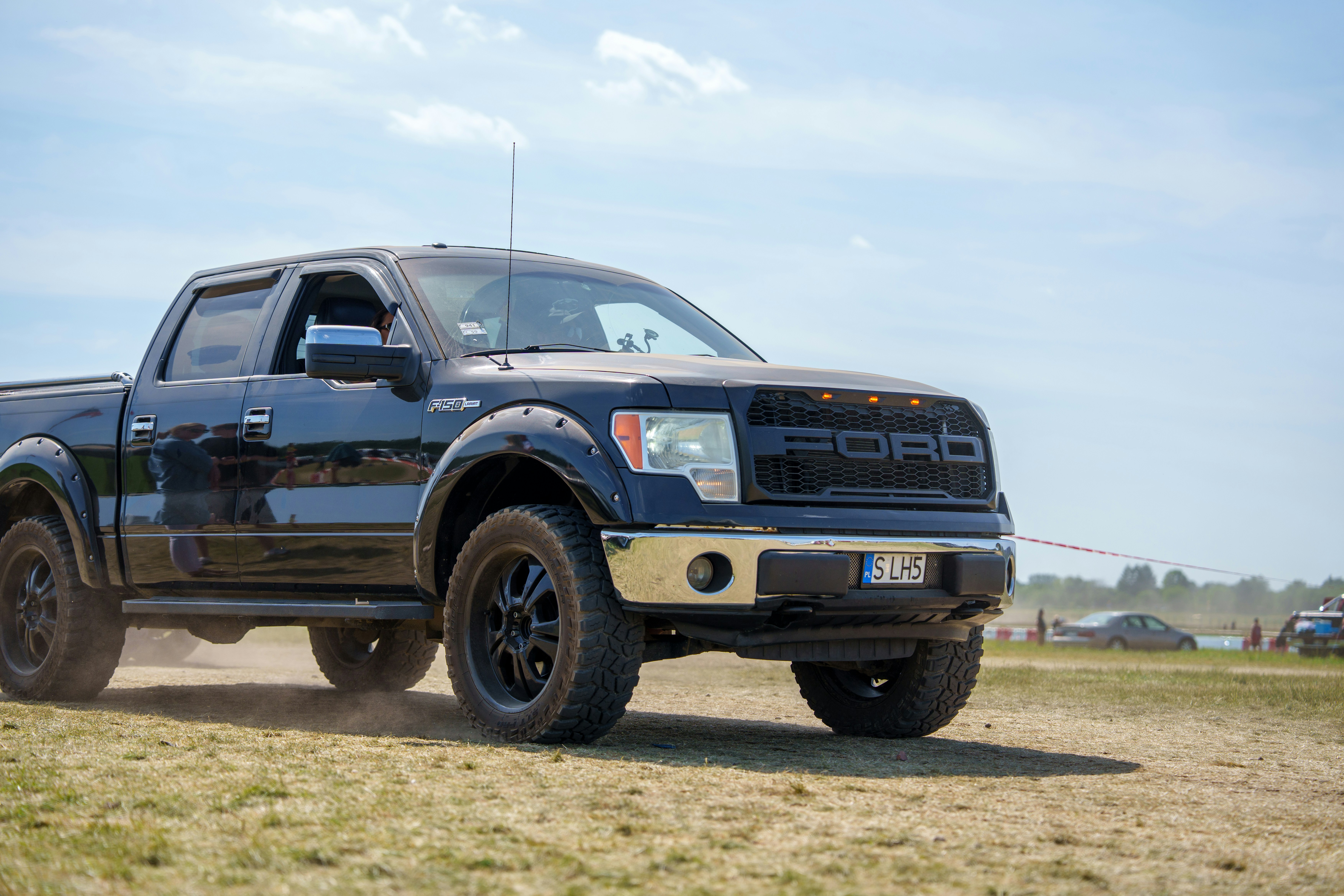 Ford F-150 Raptor in Motion Across Dusty Field