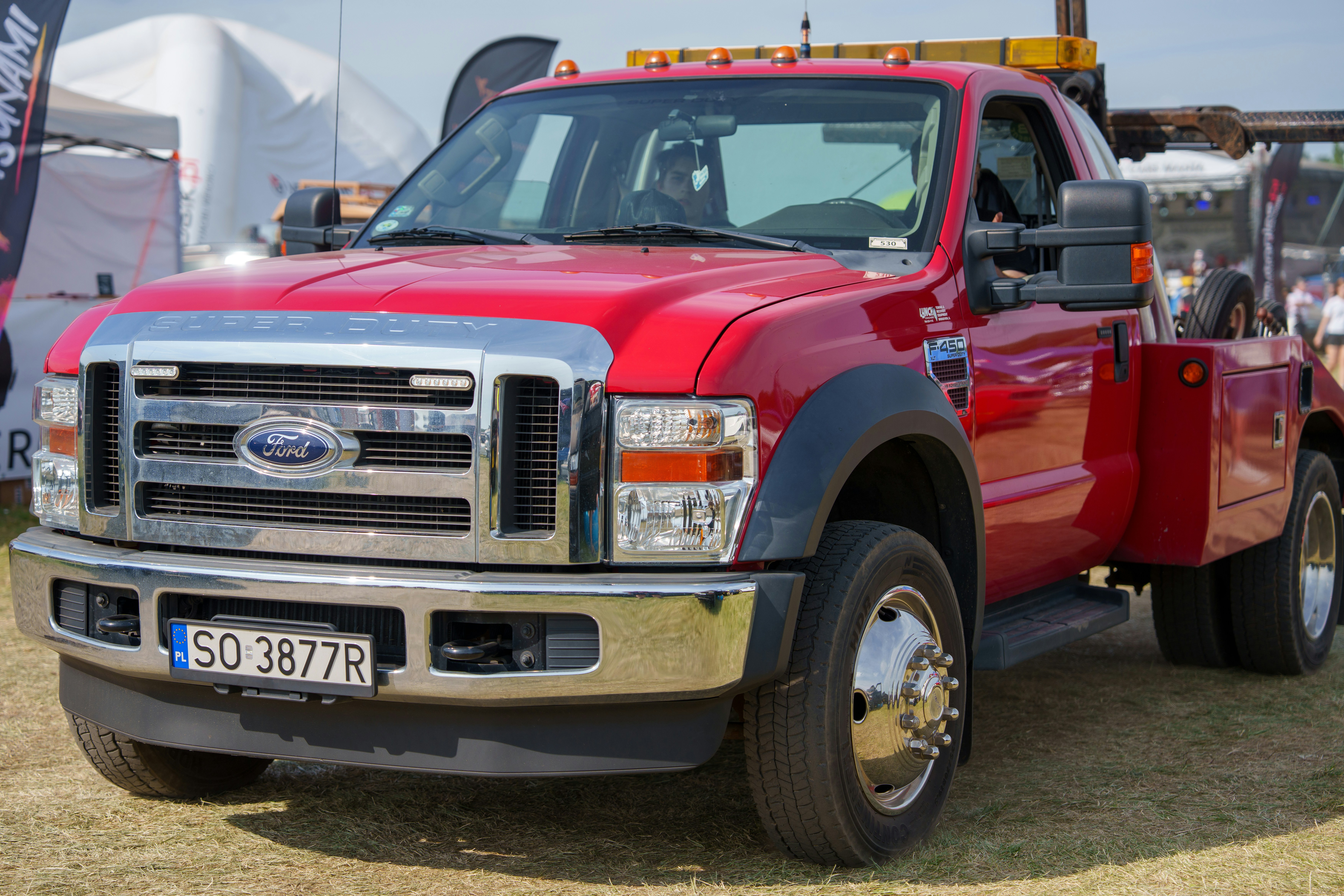 Bold Red Workhorse: Front-Long Shot of a Tow Truck at an Outdoor Exhibition