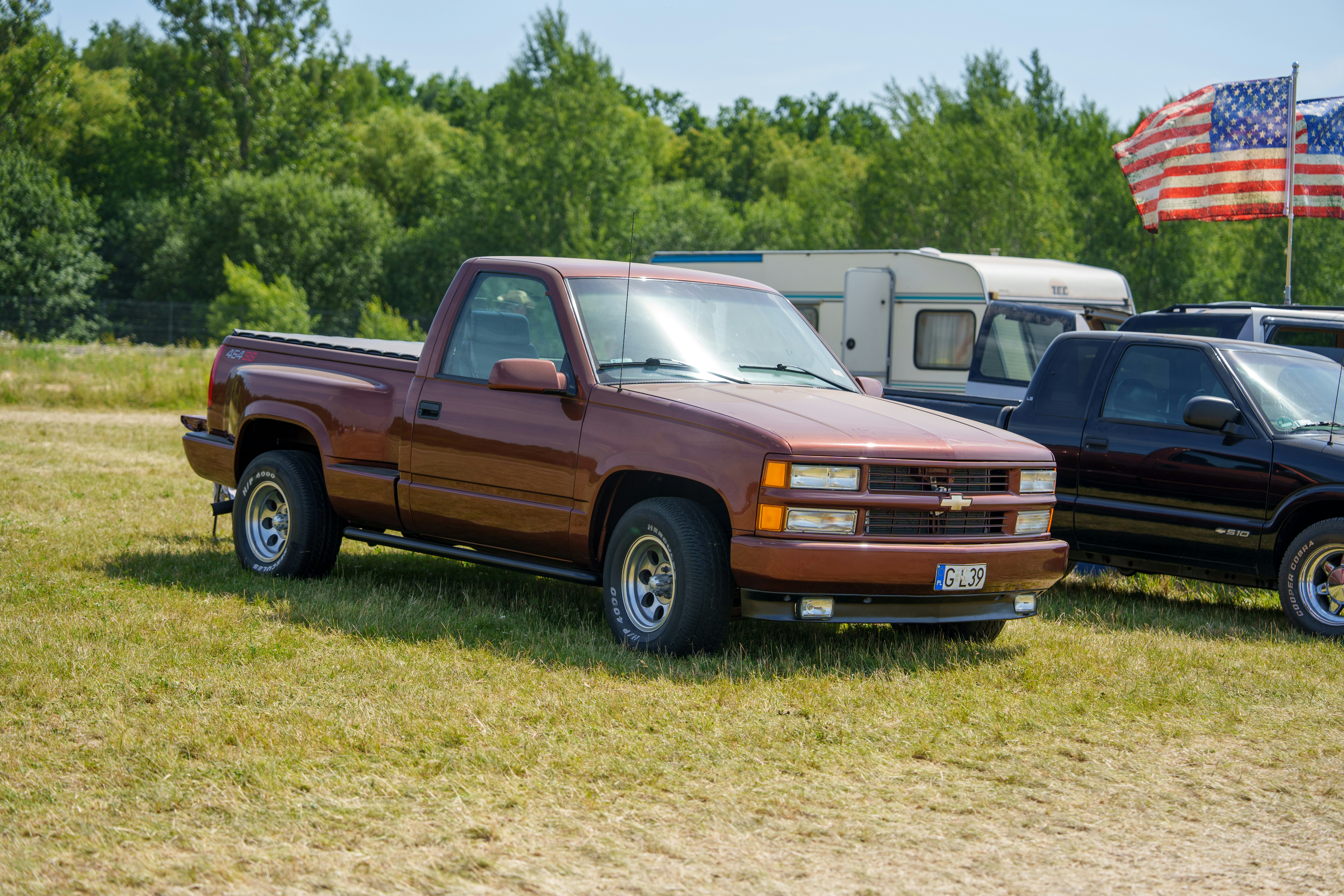 Rust-Colored Pickup Under Open Sky at a Cheerful Field Show