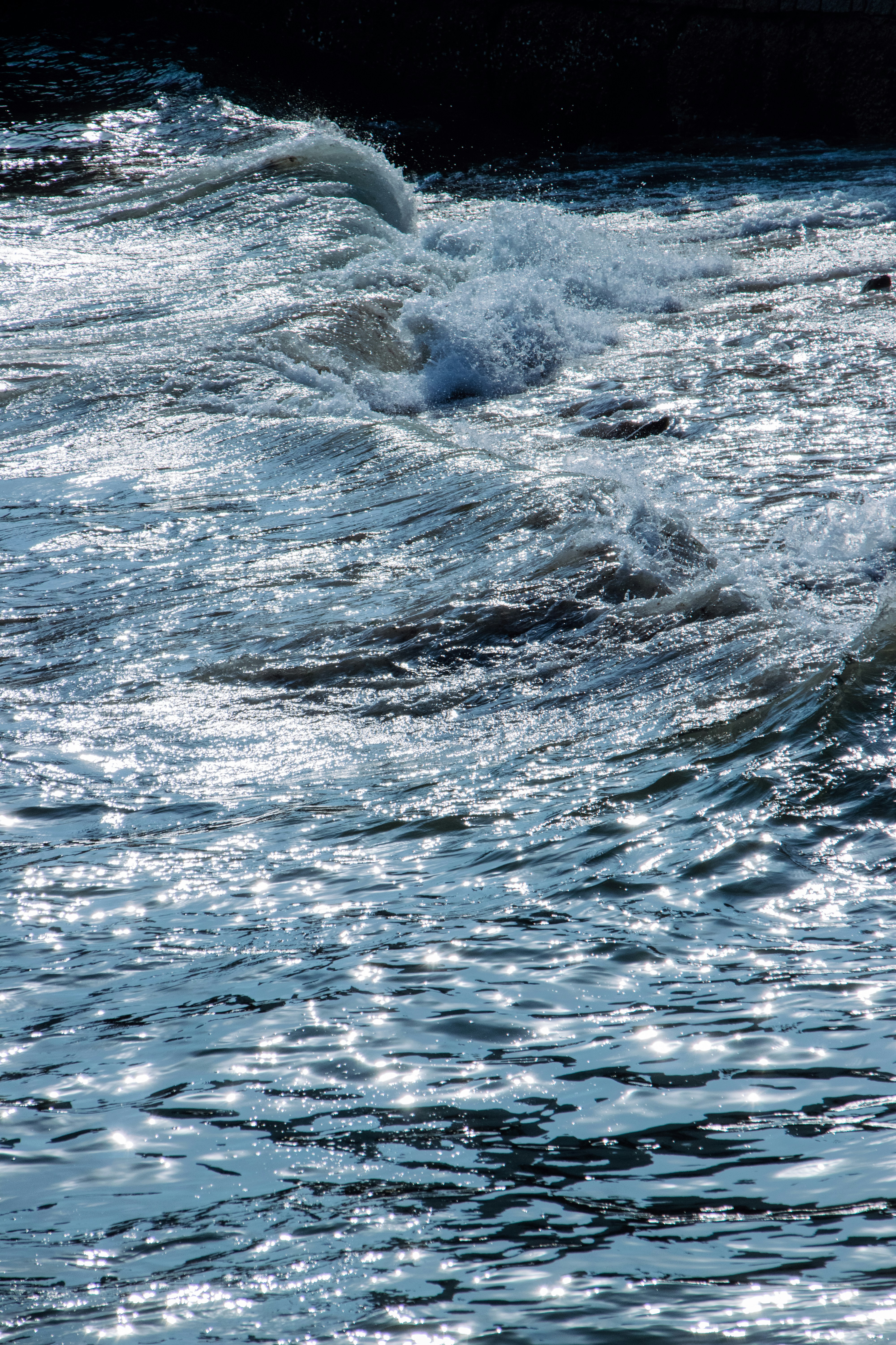 Glinting Swell: A Whimsical Dance of Light on Churning Water