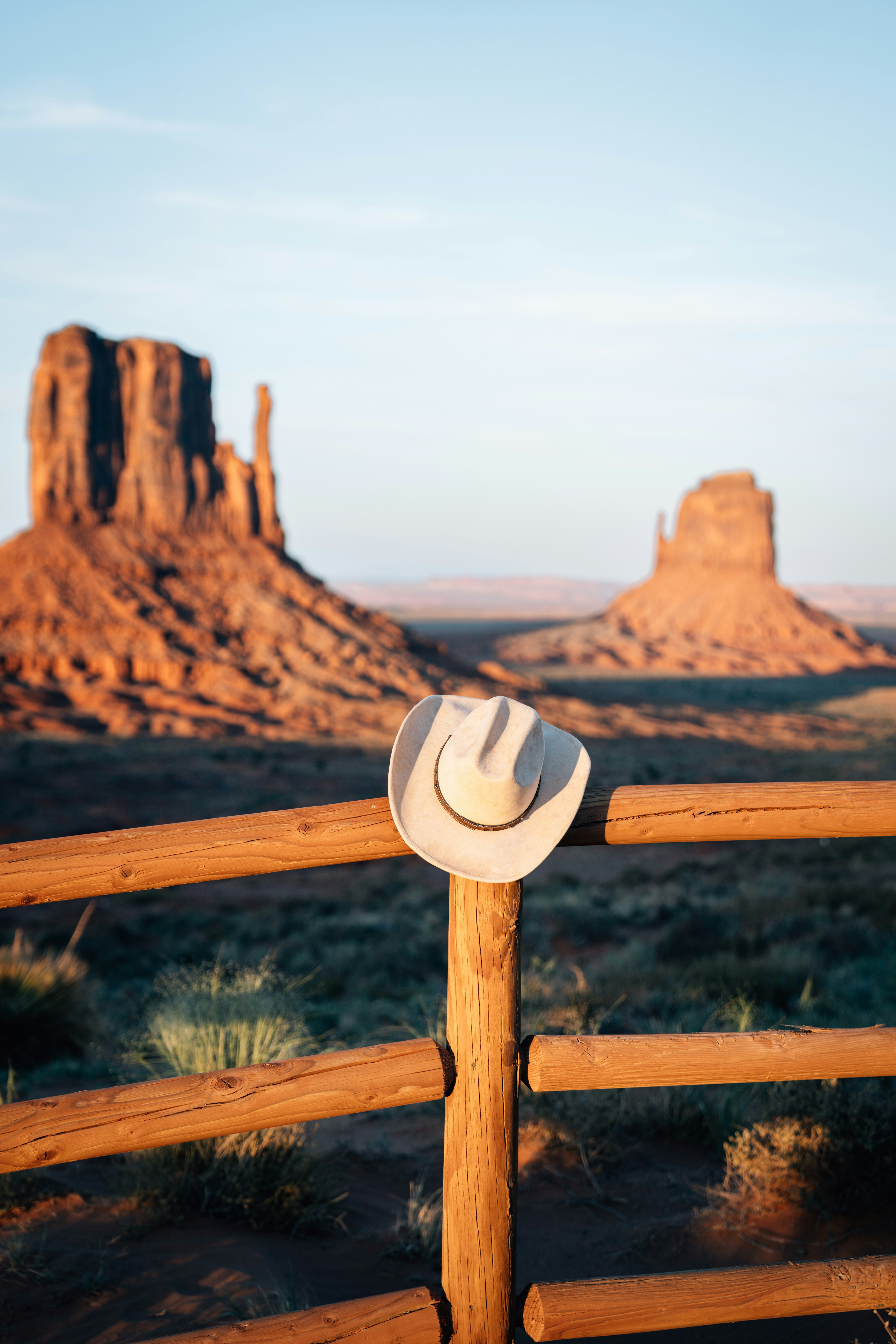 White hat on a rustic fence in Monument Valley at golden hour