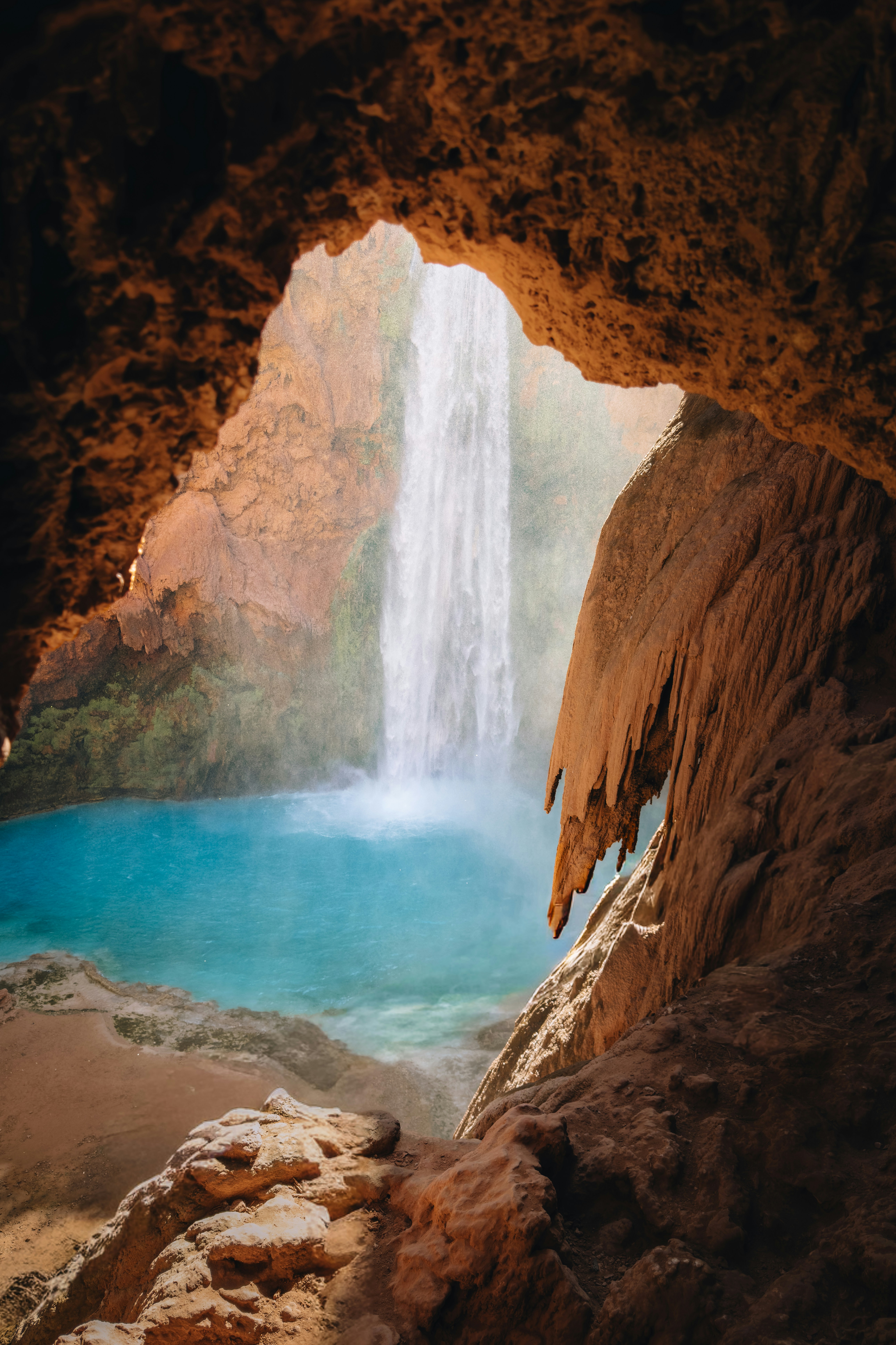 Cavern Cascade: Turquoise Pool Framed by Crimson Rock