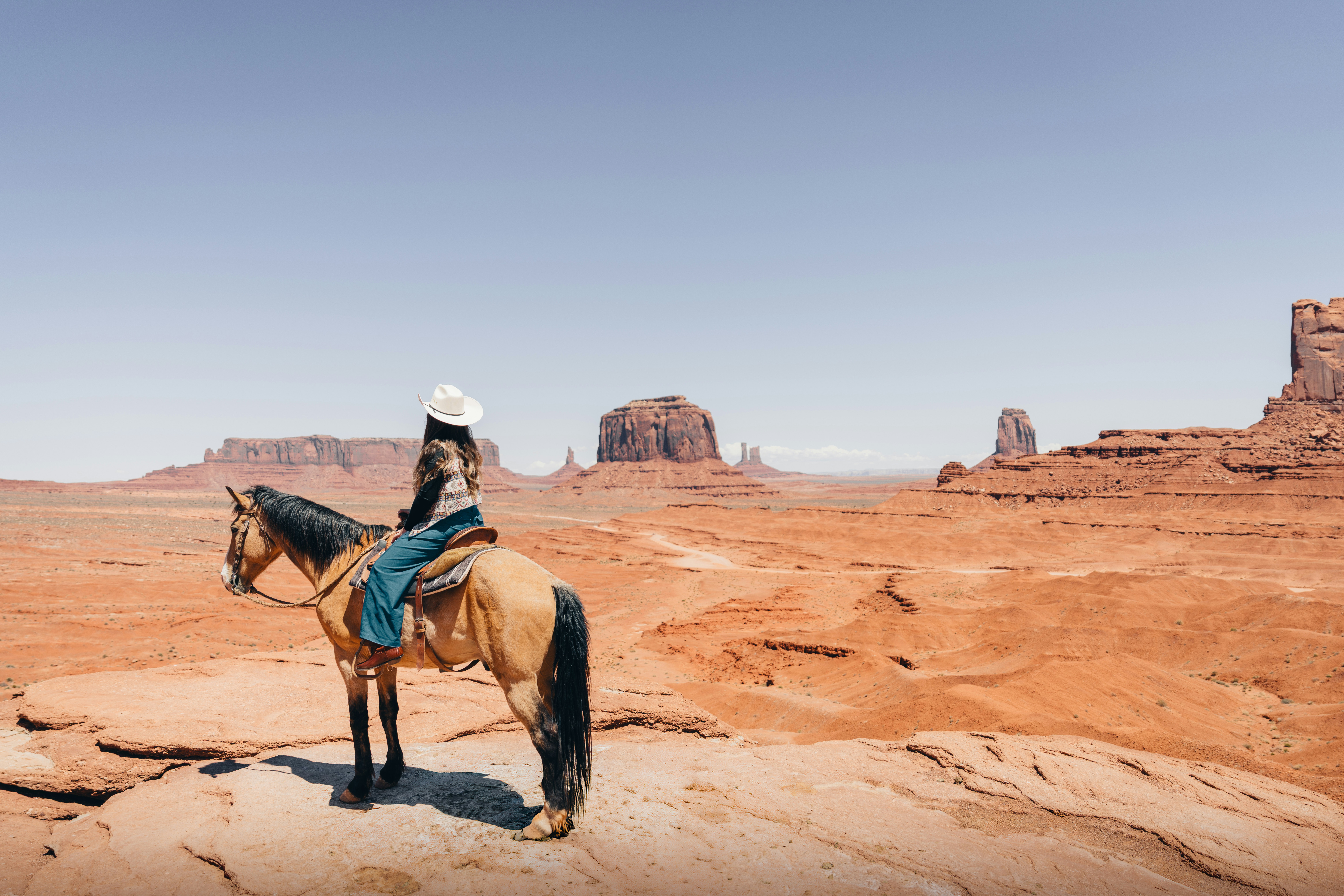 Ride Through the Painted Desert: Rider and Horse Amid Rust-Red Monoliths