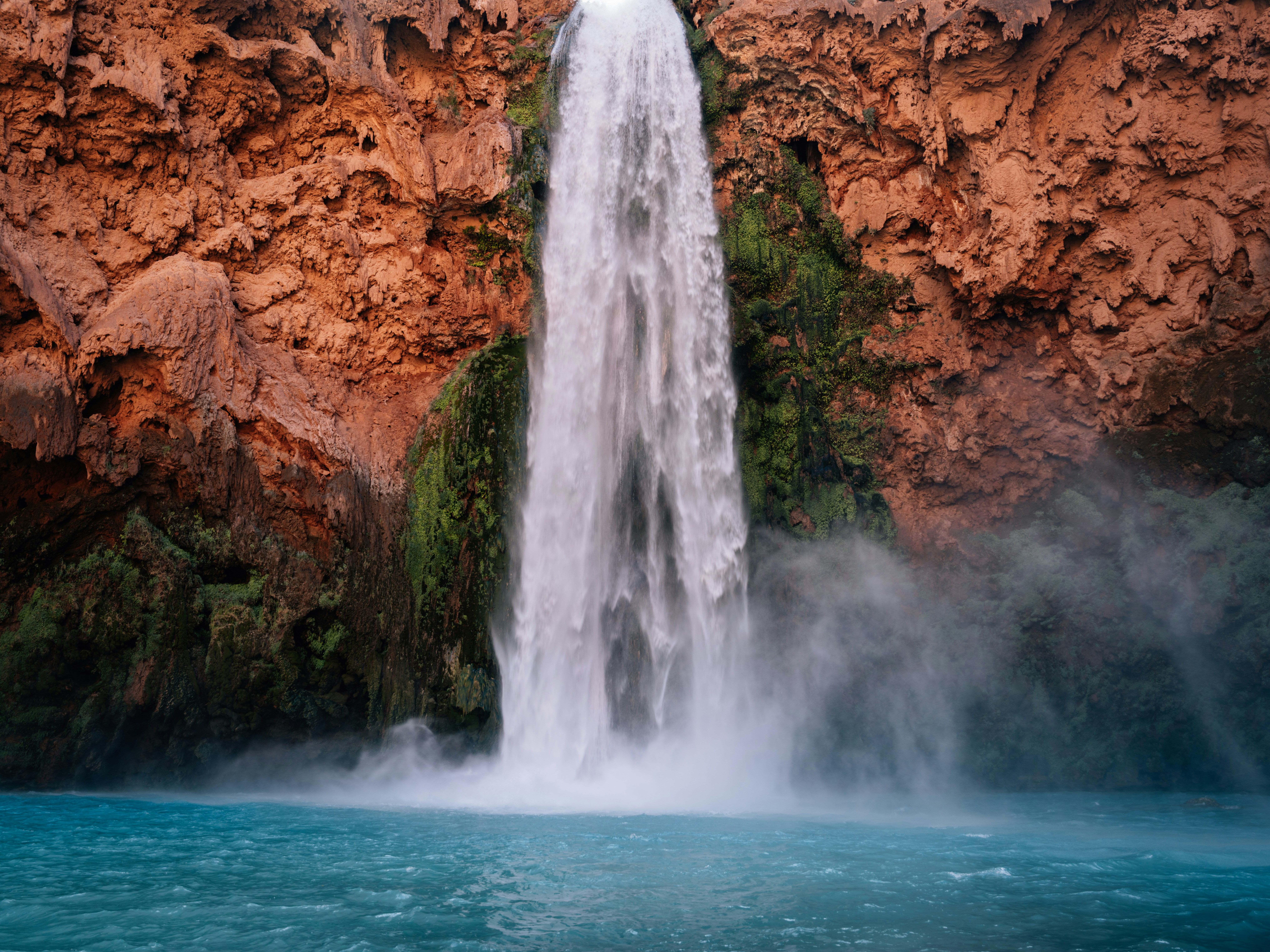 Azure Pool and Emerald Cliff: A Waterfall's Veil over Turquoise Depths