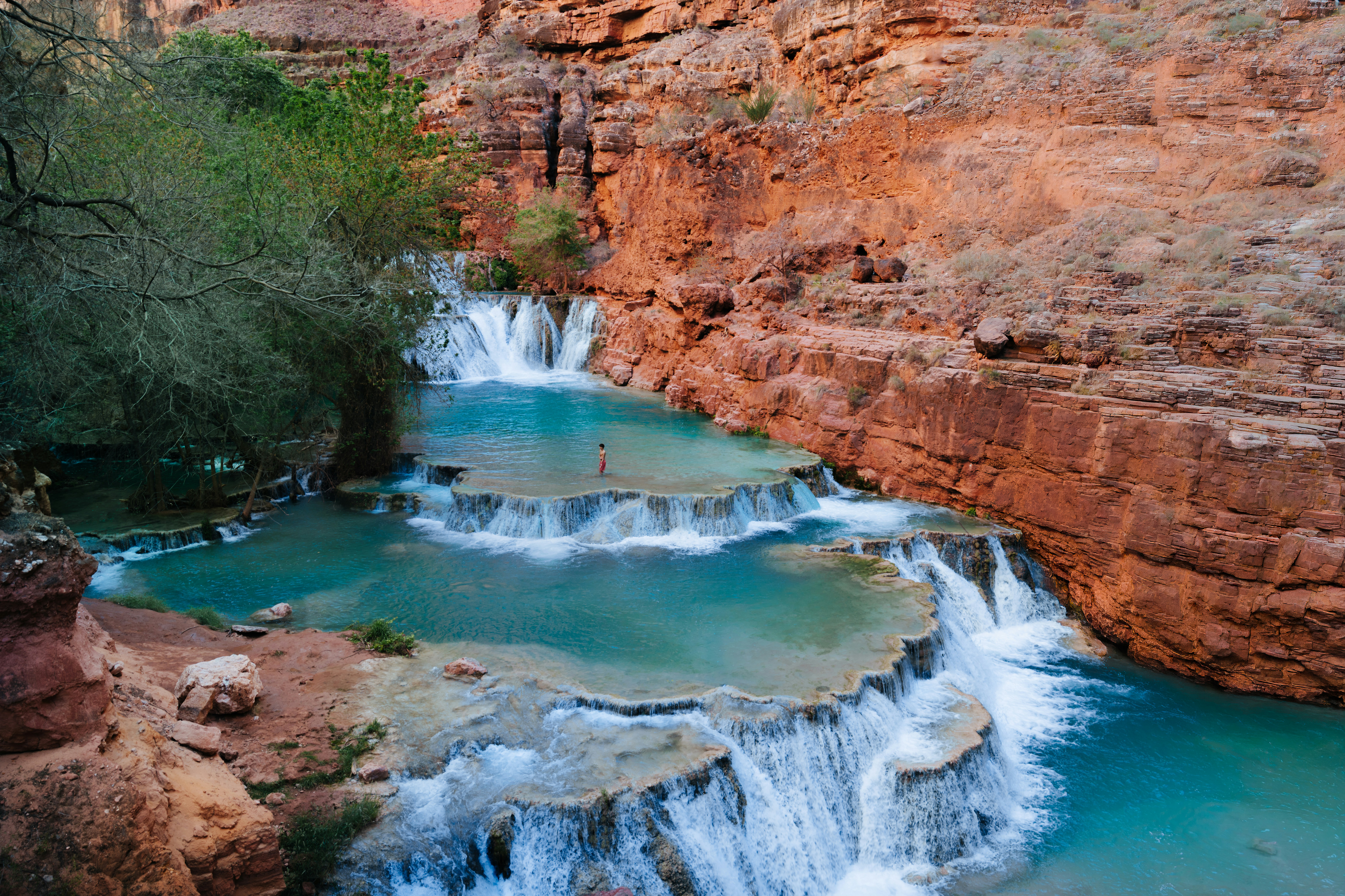 Turquoise Terraces: A Canyon’s Tiered Waterfall In Red Rock Light