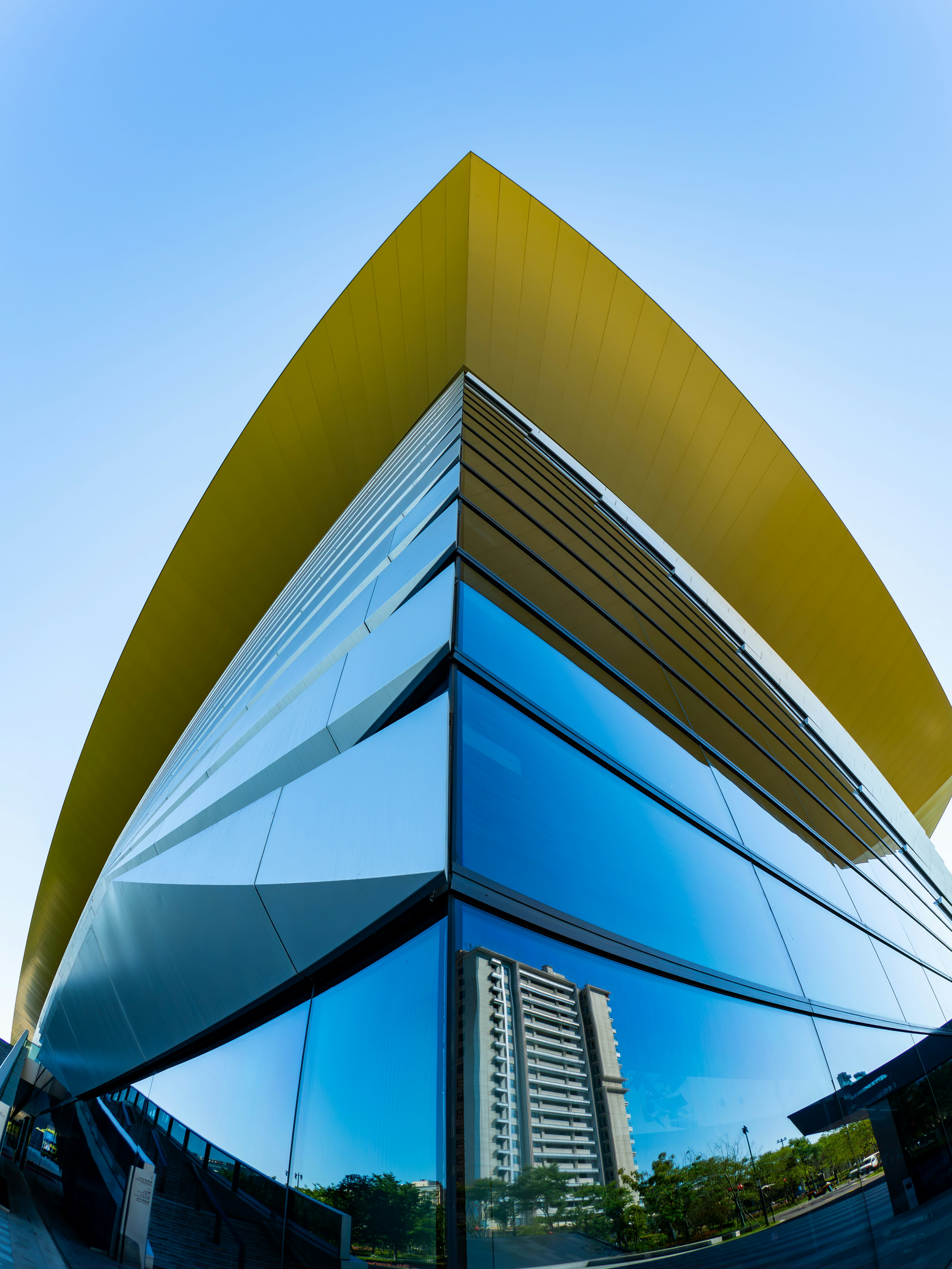 Arched Golden Canopy Over a Mirrored Glass Structure