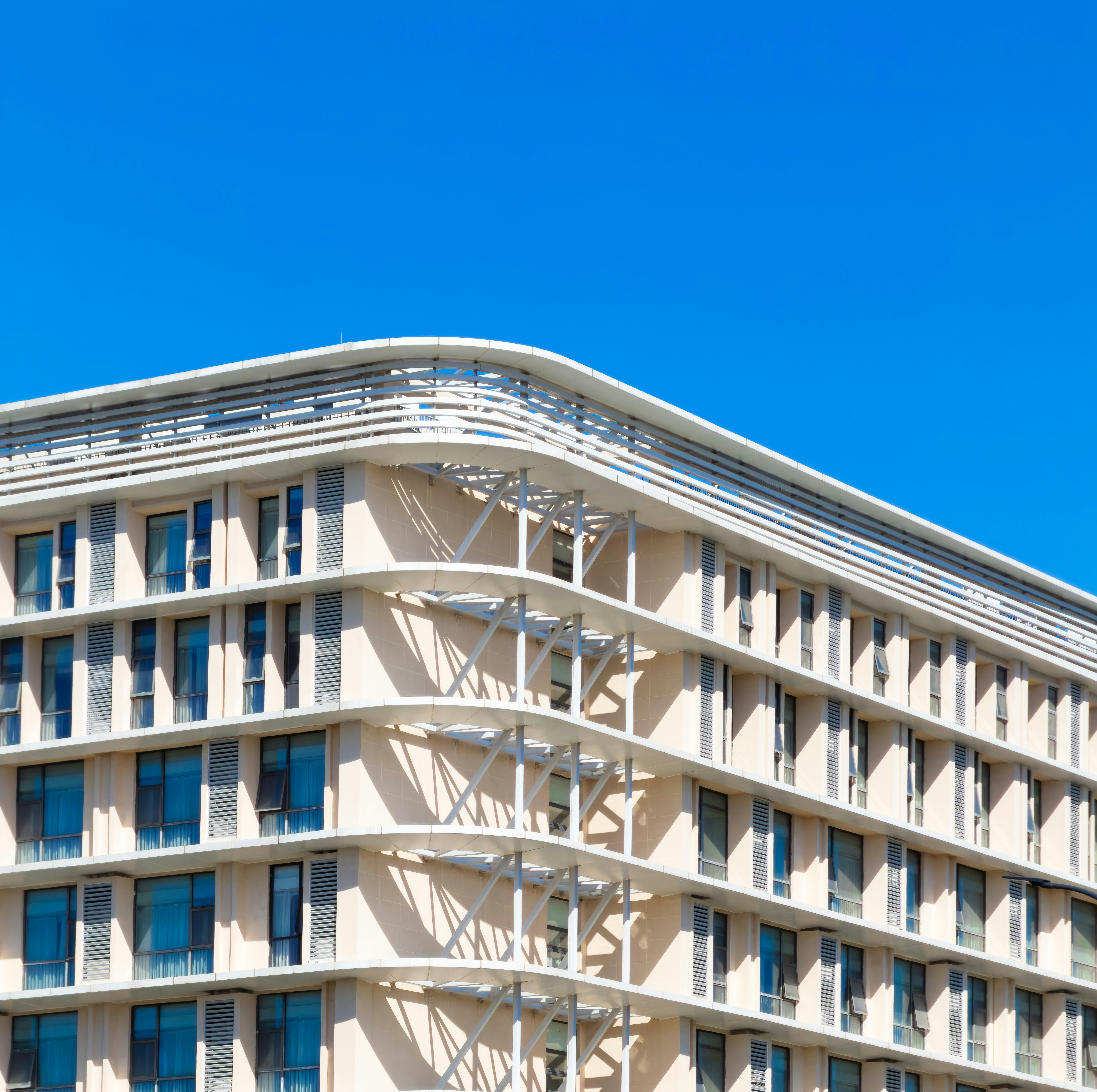 Cornerstone of Light: Sunlit Modern Facade Rising Against a Clear Sky