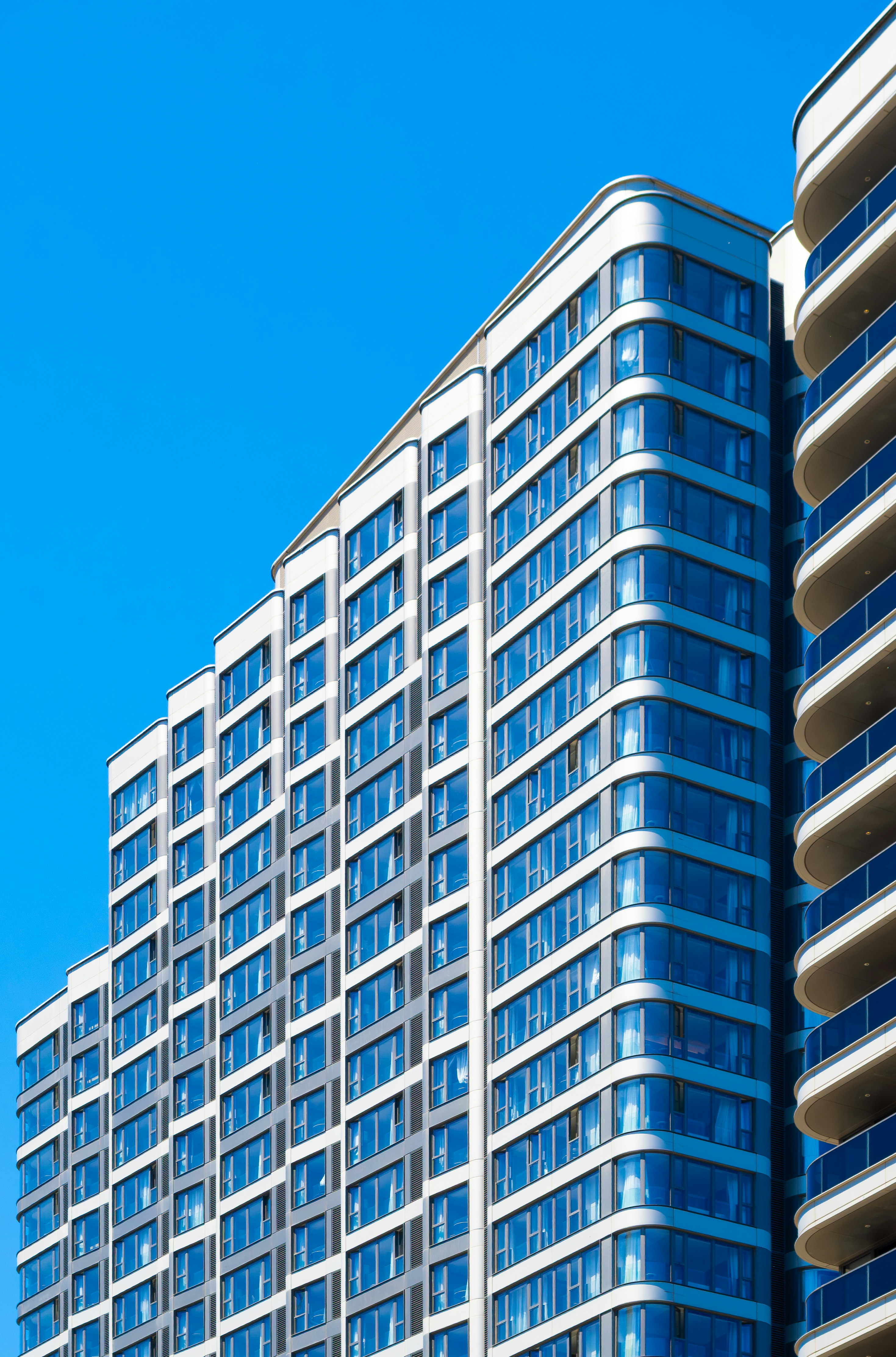 Architectural Rhythm: Glass Facades Lean into a Clear Blue Sky