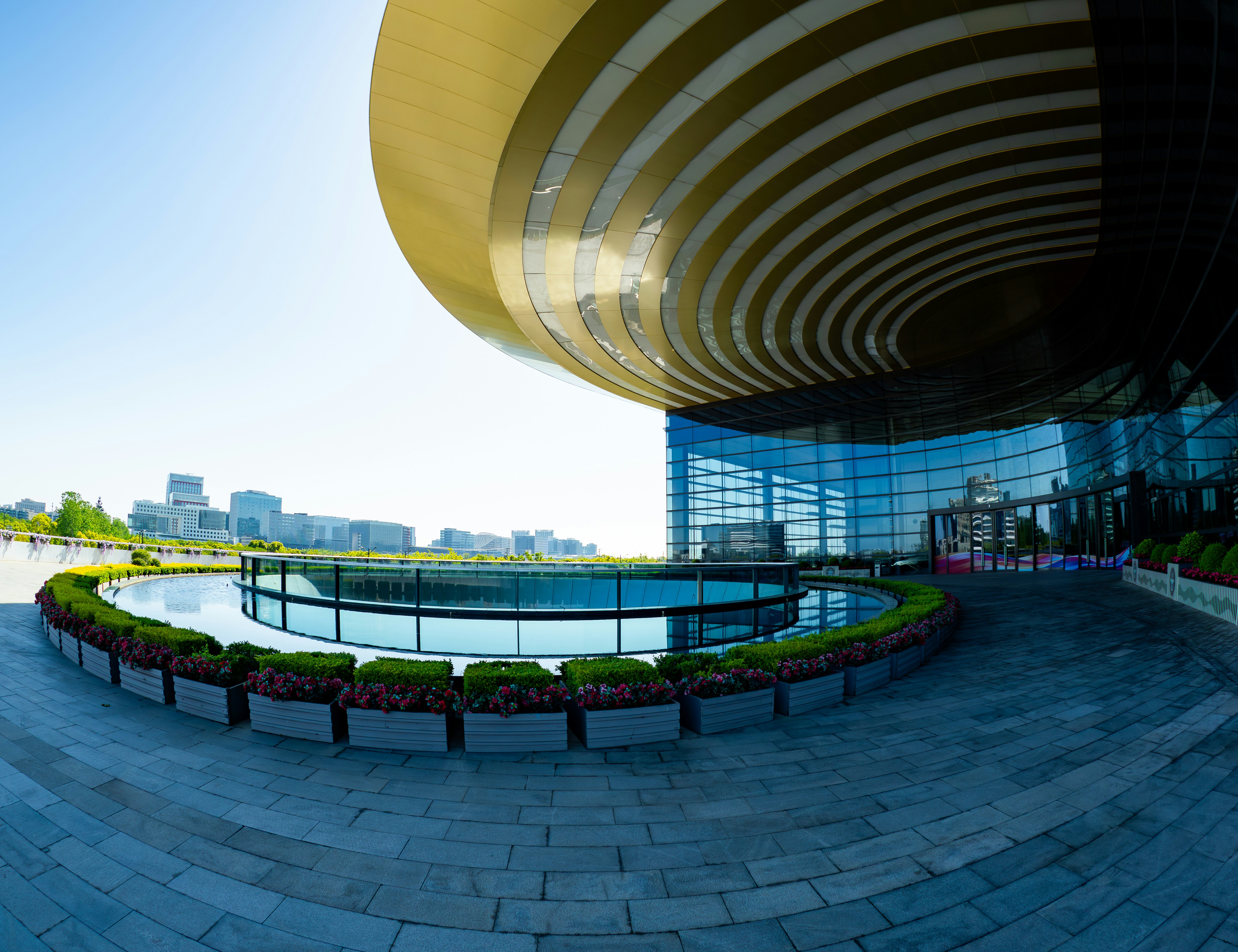 Curved Facade, Calm Plaza: Modern Architecture by the Water