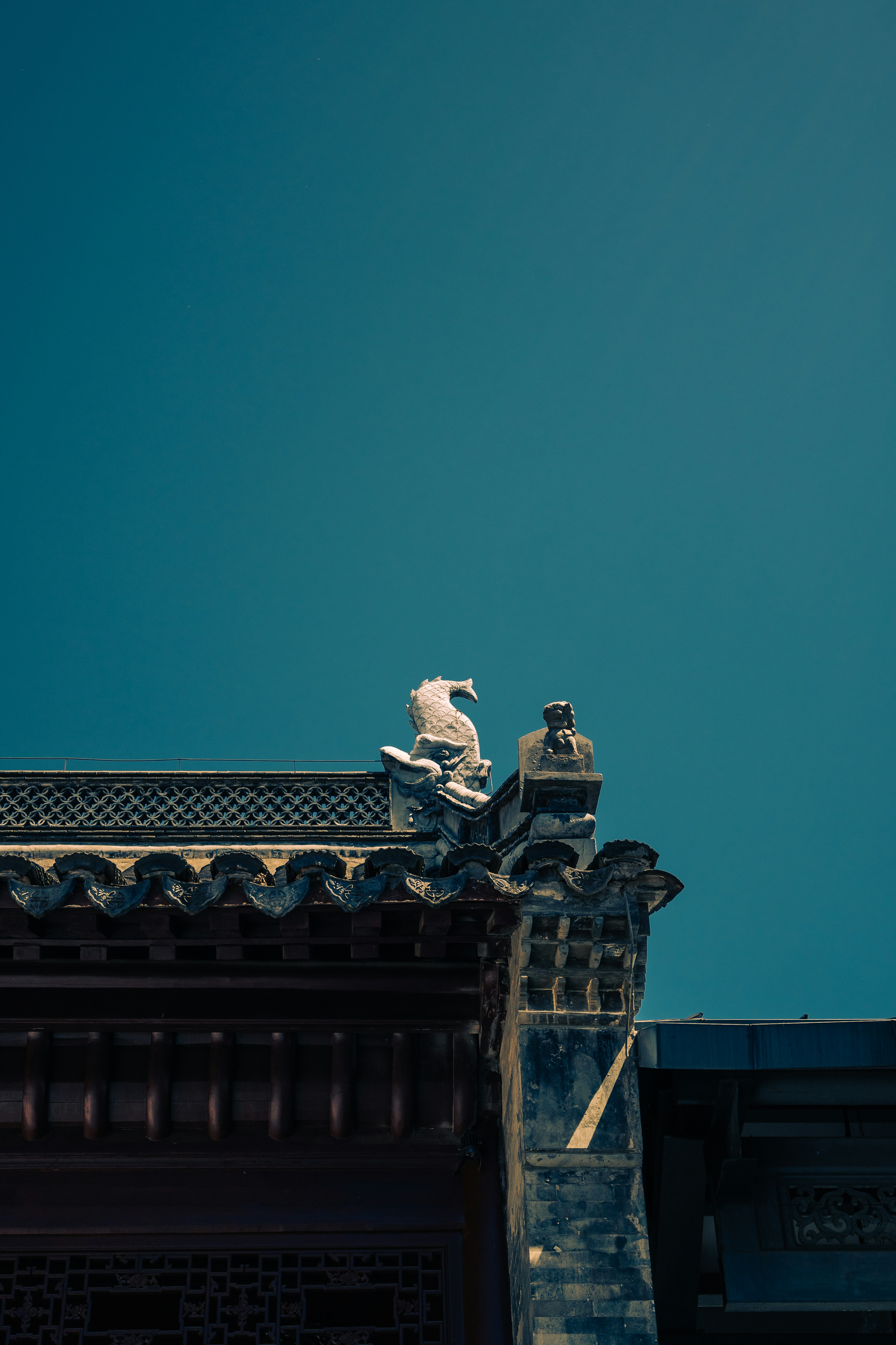 Stone Chimera Silhouette Beneath a Calm Teal Sky