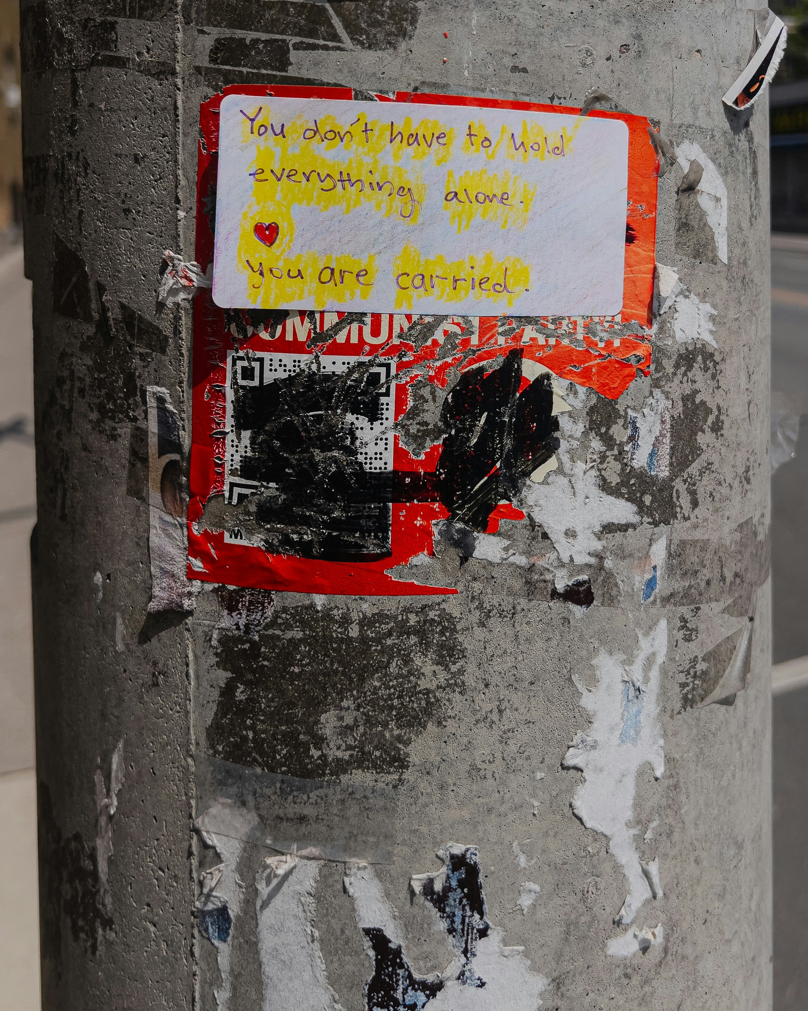 Stickered Concrete: A Weathered Urban Post with Layered Remnants