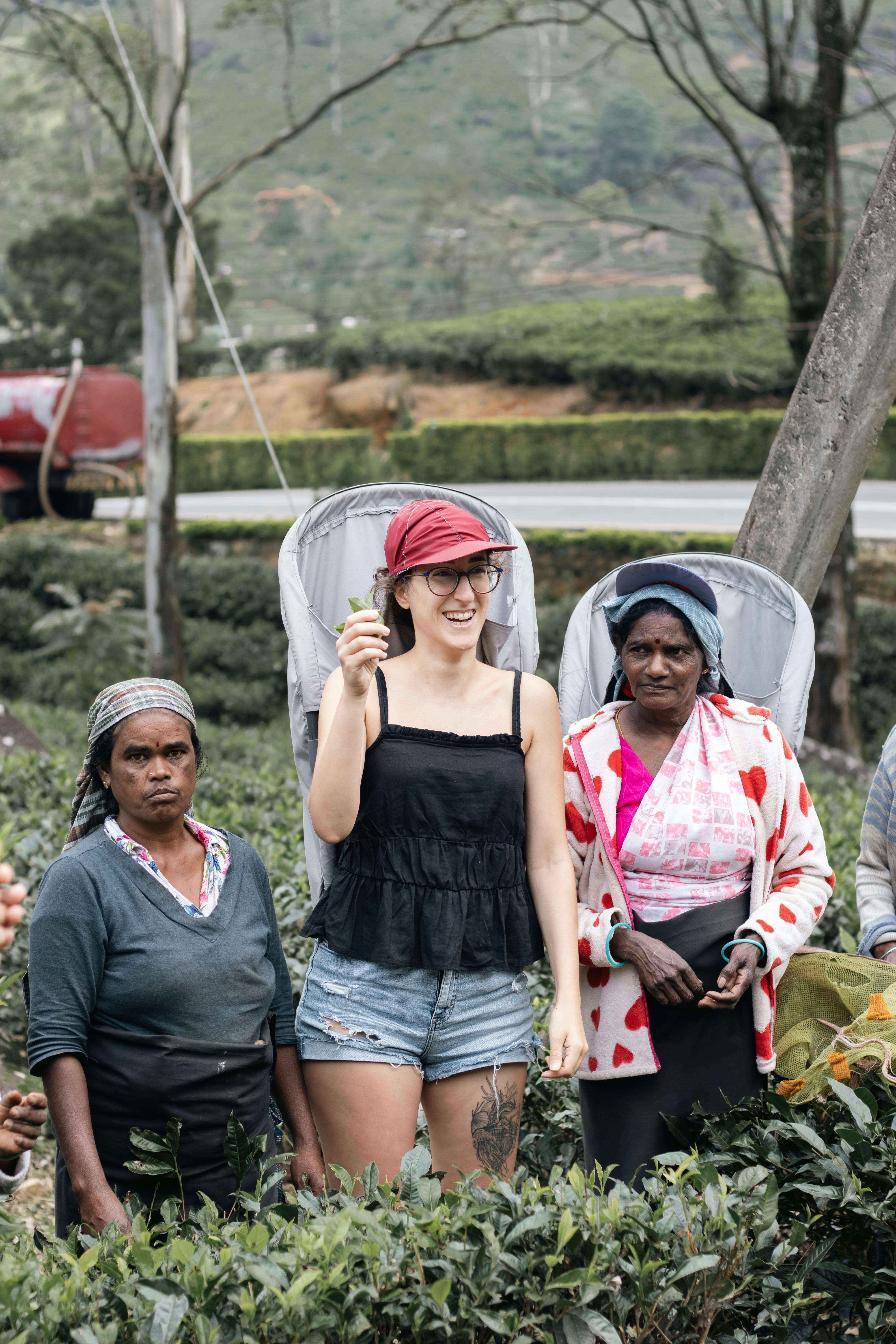 Smiling Tourist among tea field locals under a shaded canopy