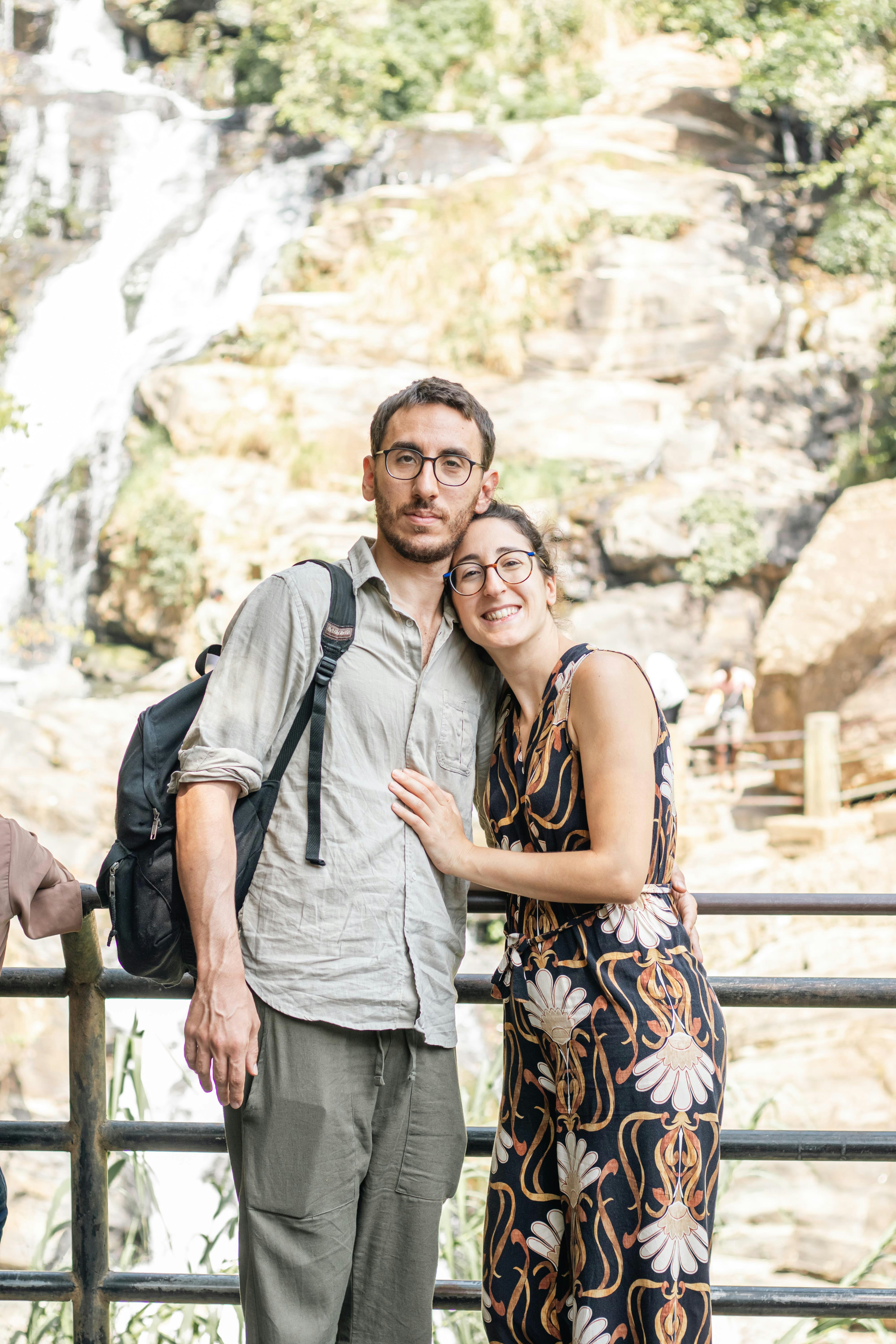 Couple by the waterfall: a sunlit moment of companionship