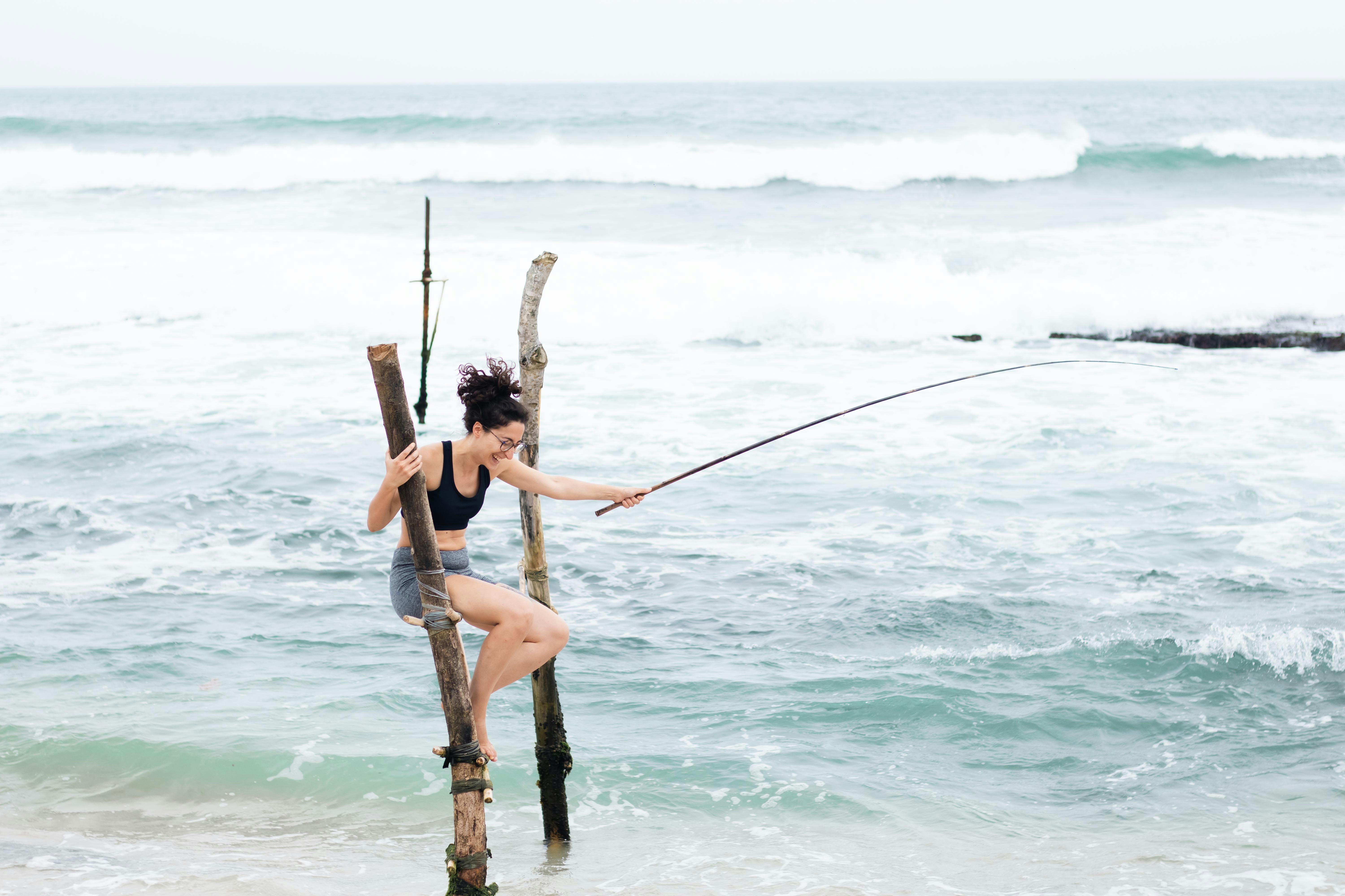 Tethered in Tide: A Surfer Silhouette on Poles at Sea