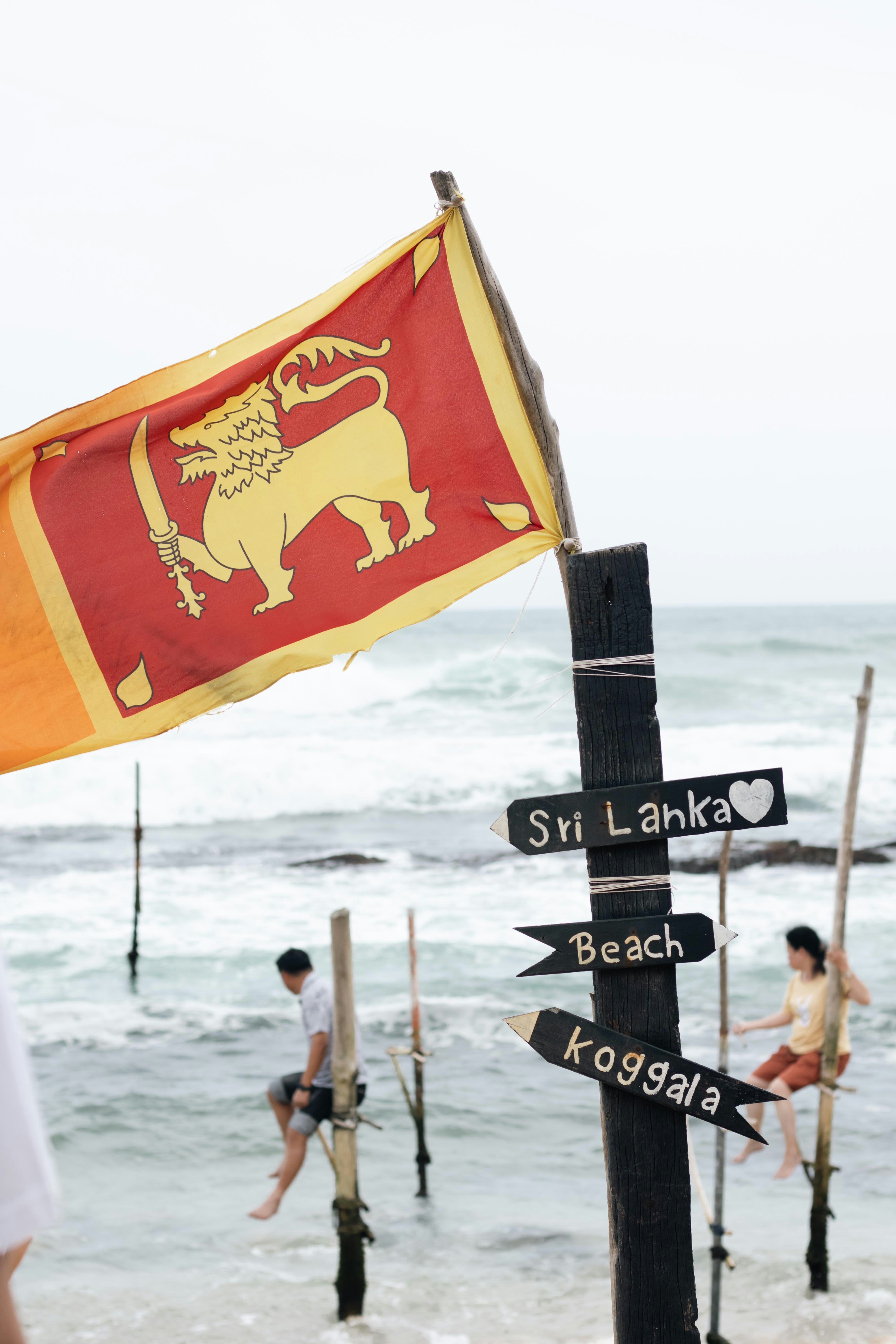 Flag of Sri Lanka in a breezy beach scene with wooden signs