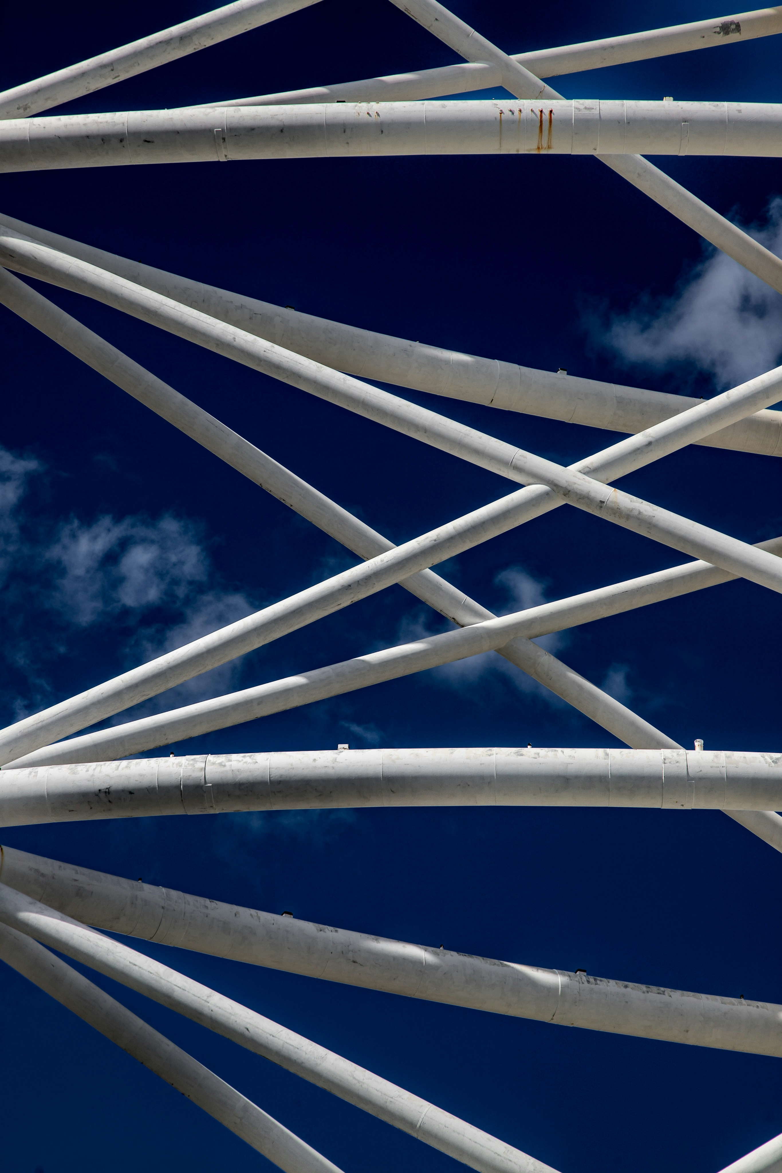 Crisscross of White Rails Against a Deep Blue Sky