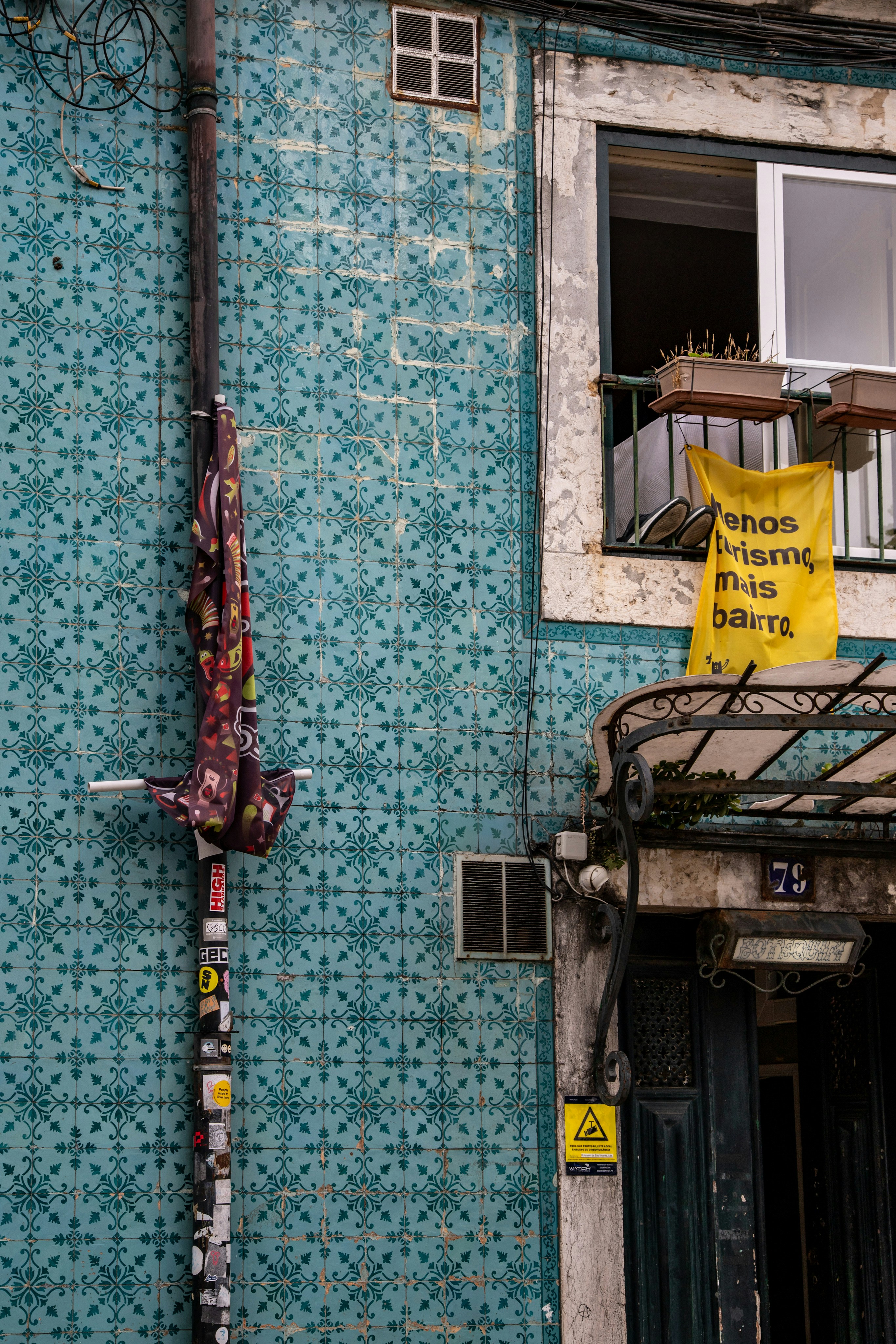 Turquoise Tiles and Yellow Banner Above a Worn City Door