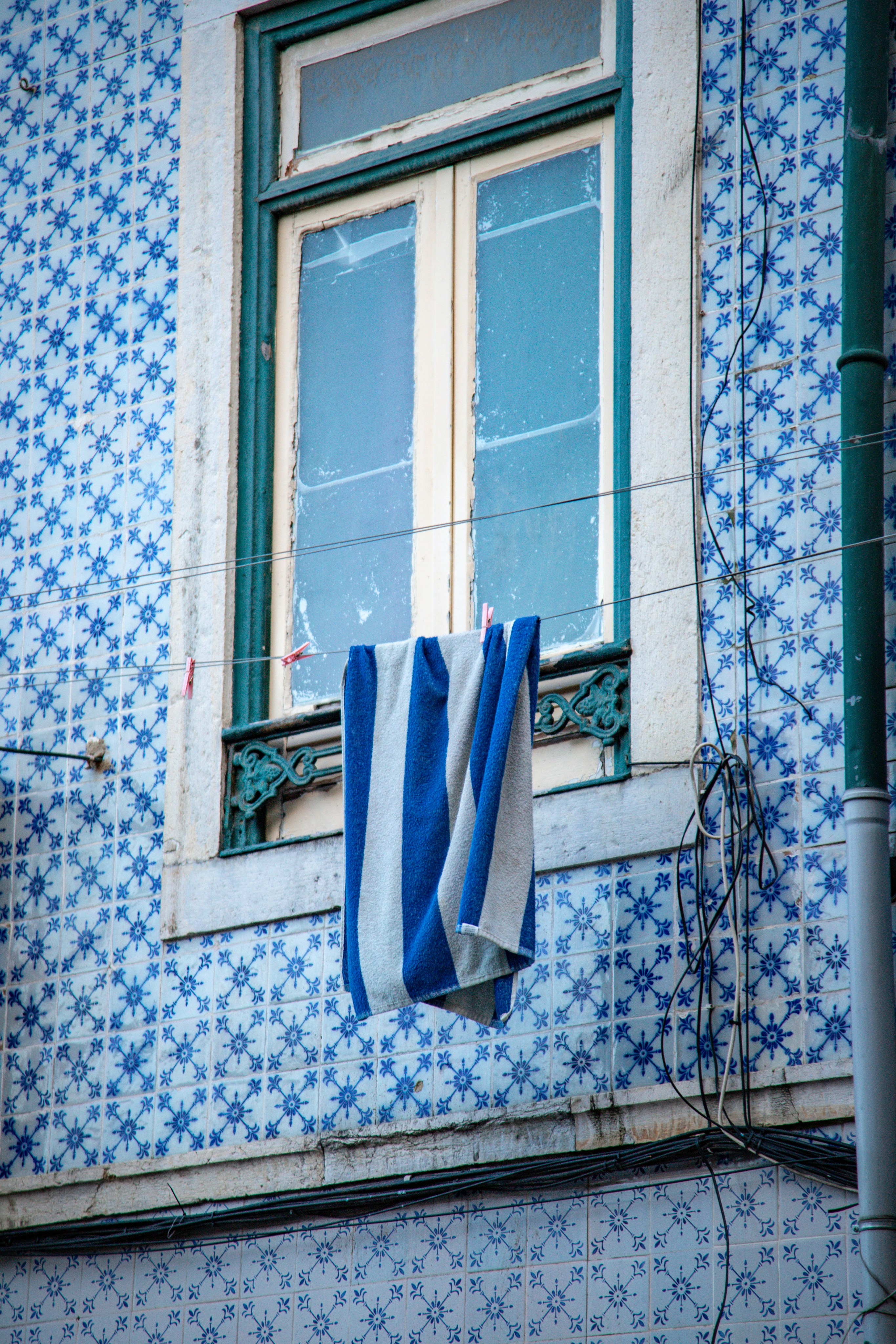 Blue Laundry Against Azulejo Veil: A Quiet Moment on a Facade