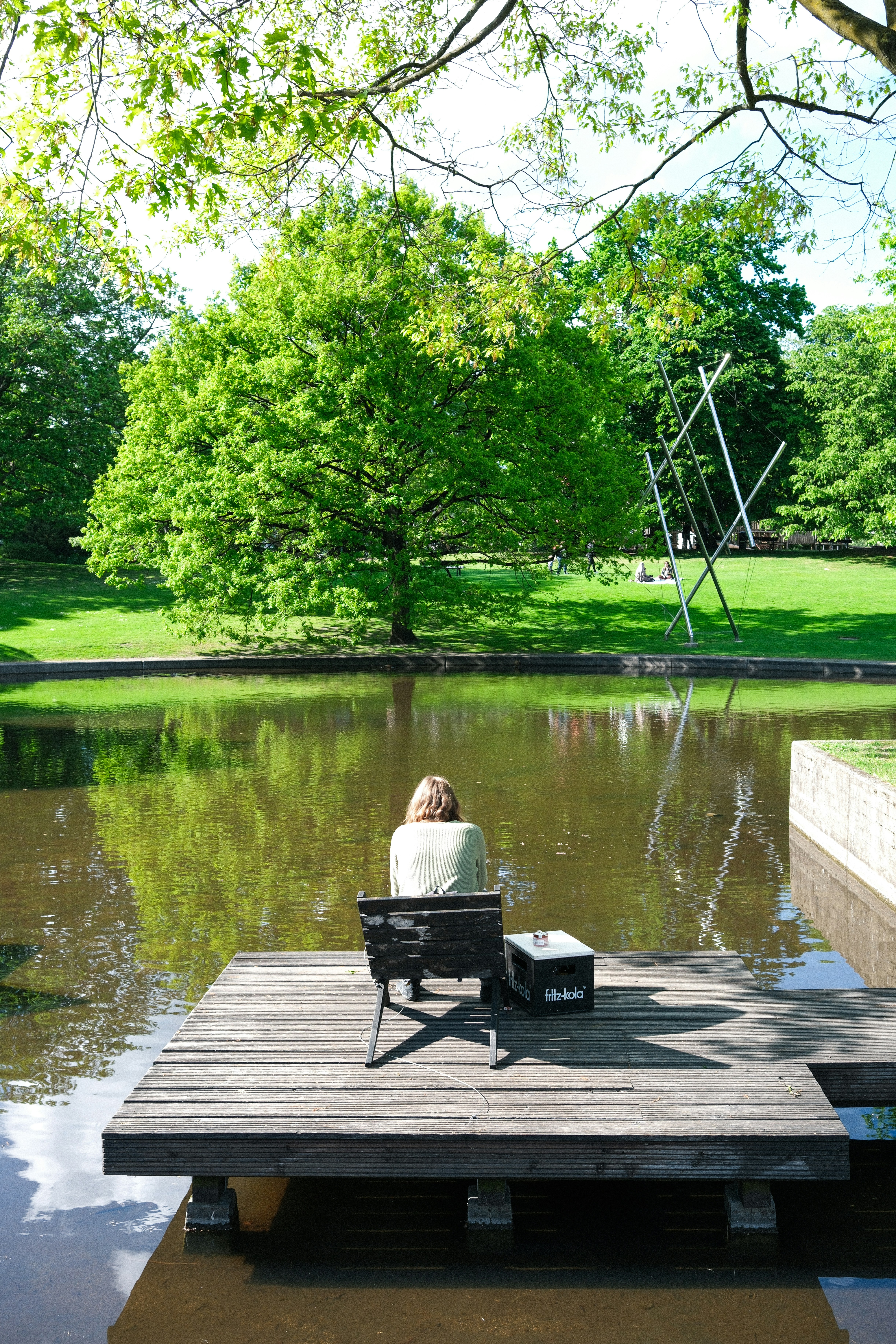 Serene Riverside Moment: A lone listener on a weathered dock