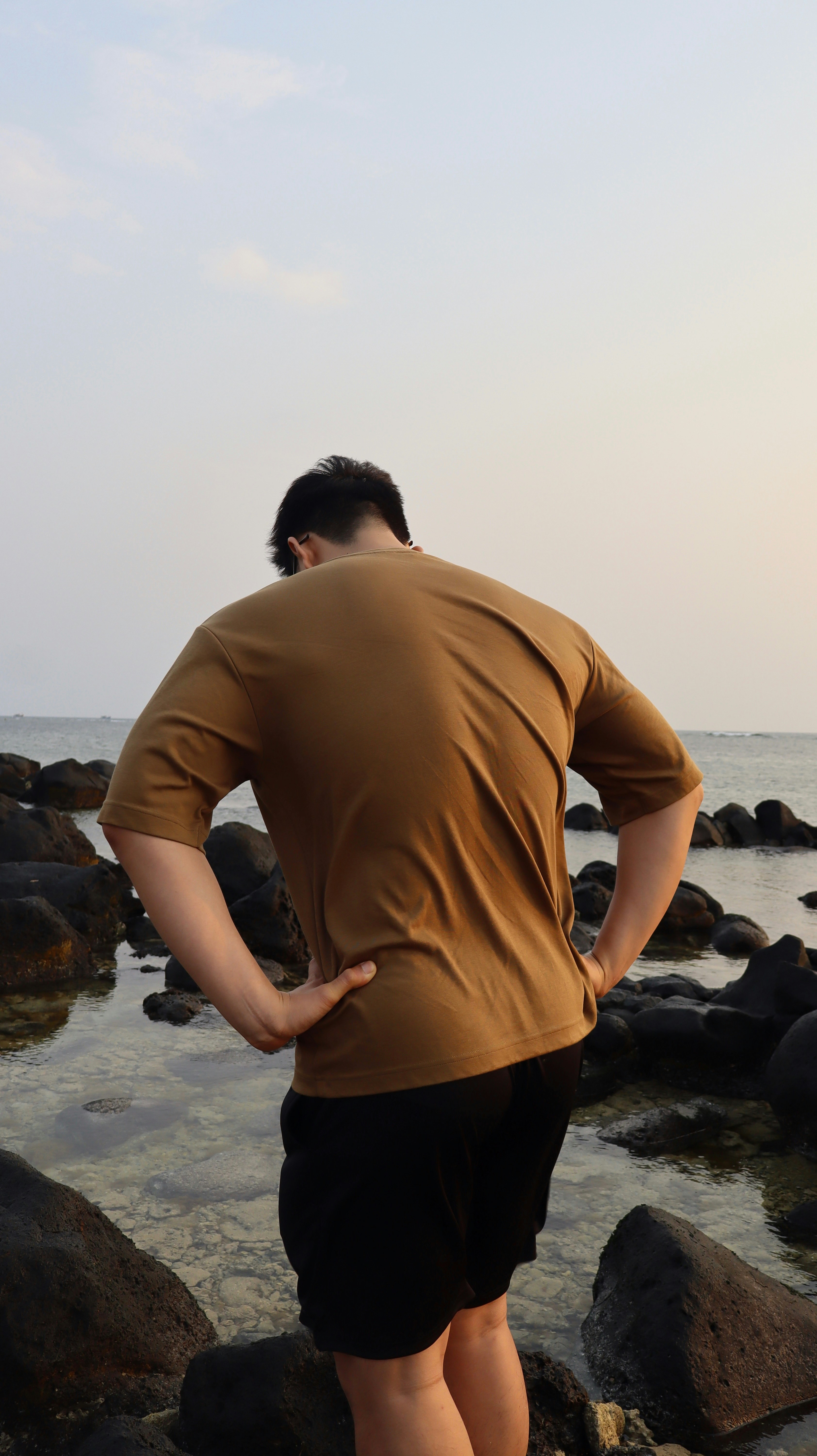 Backlit by the Sea: A Quiet Pose Along the Rocky Shore