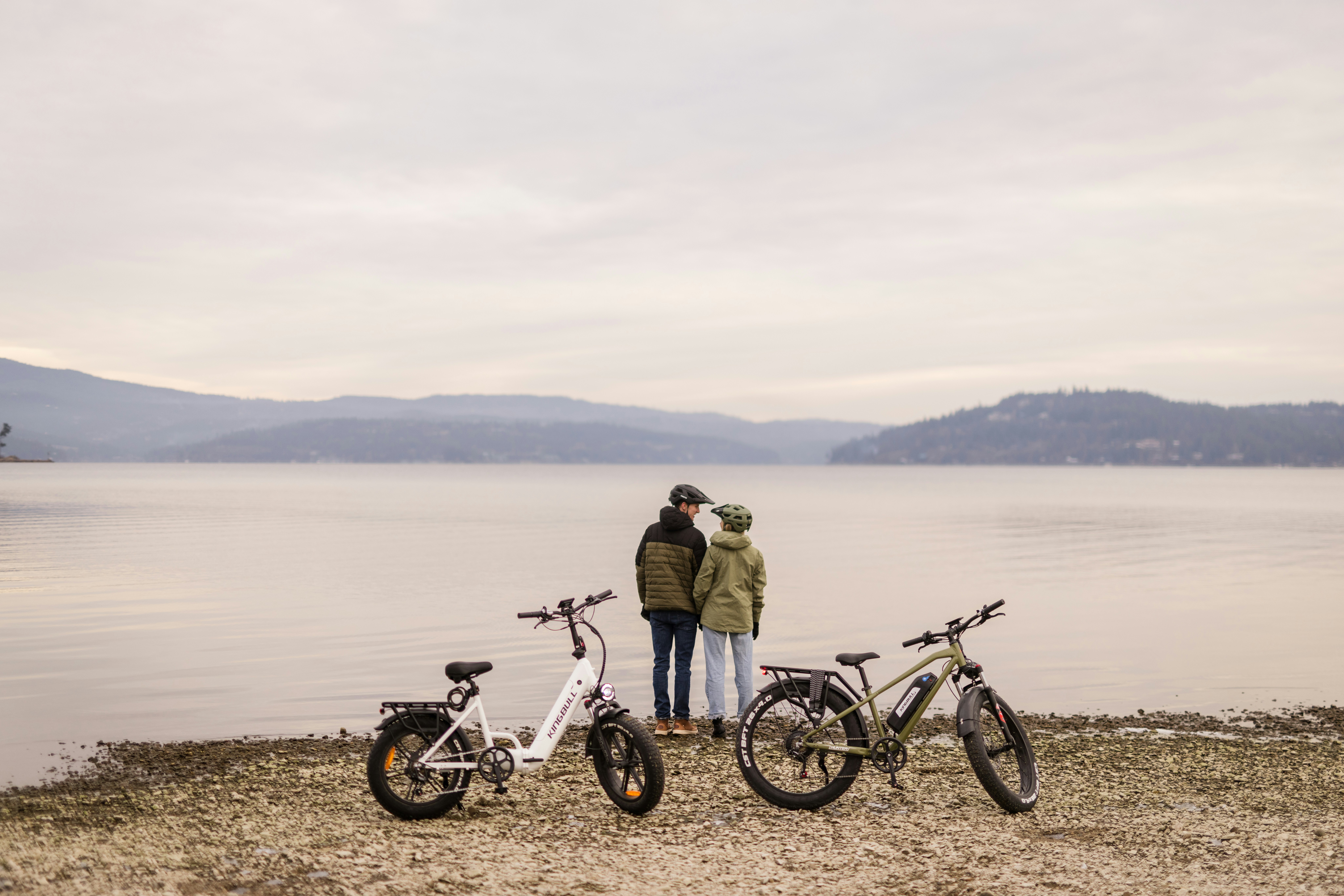 Two Travelers by the Quiet Lakefront with E-bikes