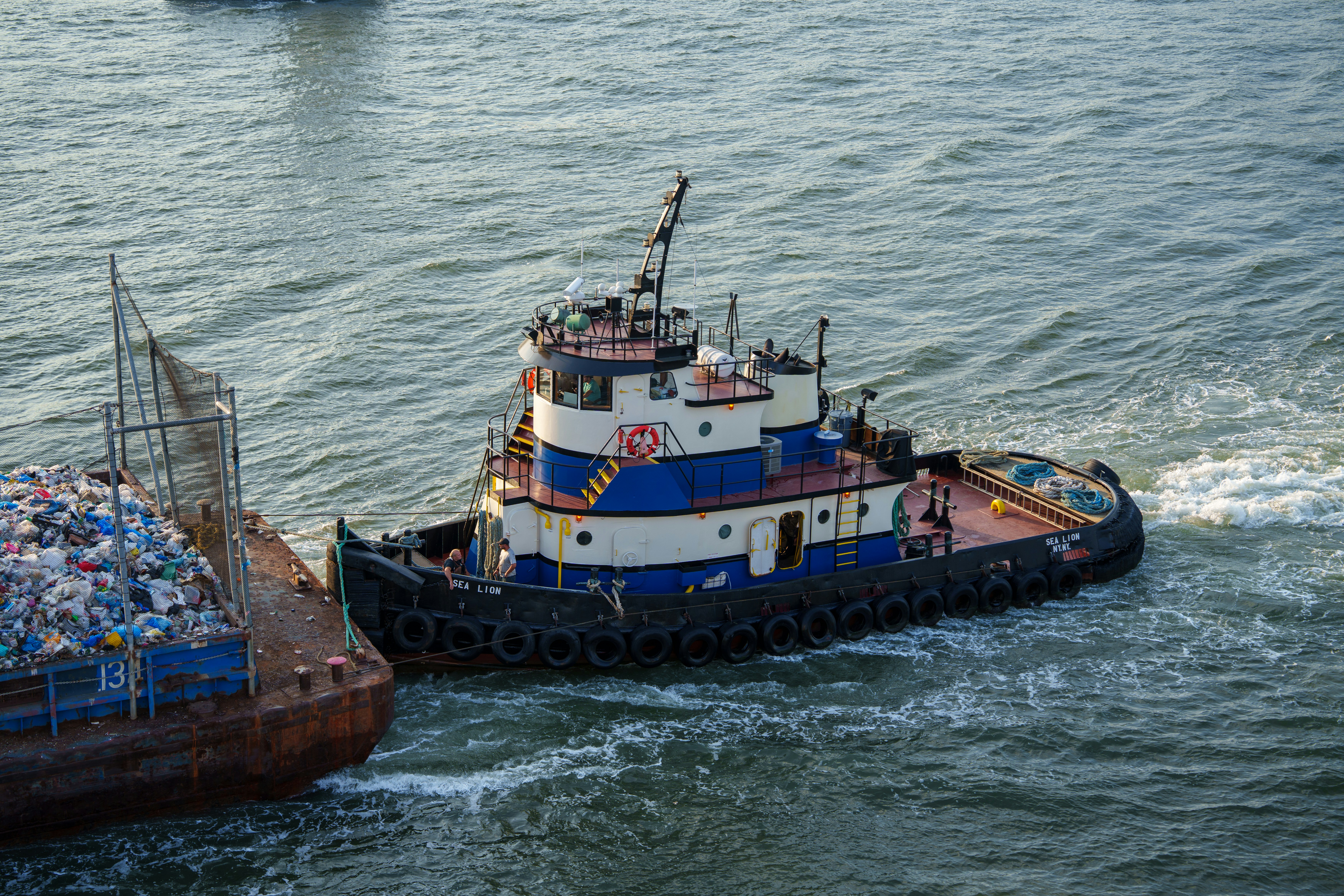 Towline Sentinel: A Tugboat Nuzzles the Dock Amid Choppy Seascape