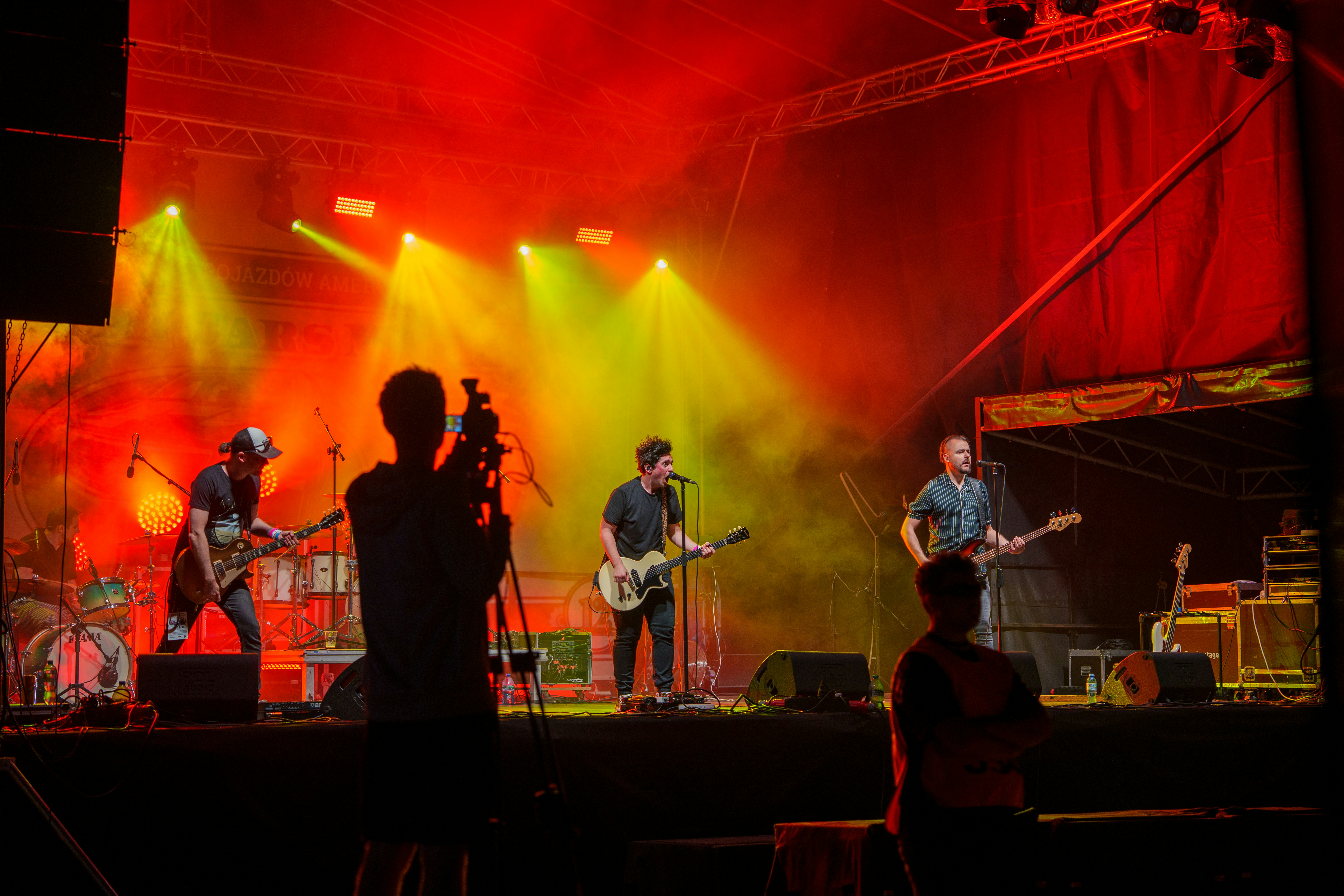 Stage Lights and Guitar Trio Under Fiery Red Atmosphere