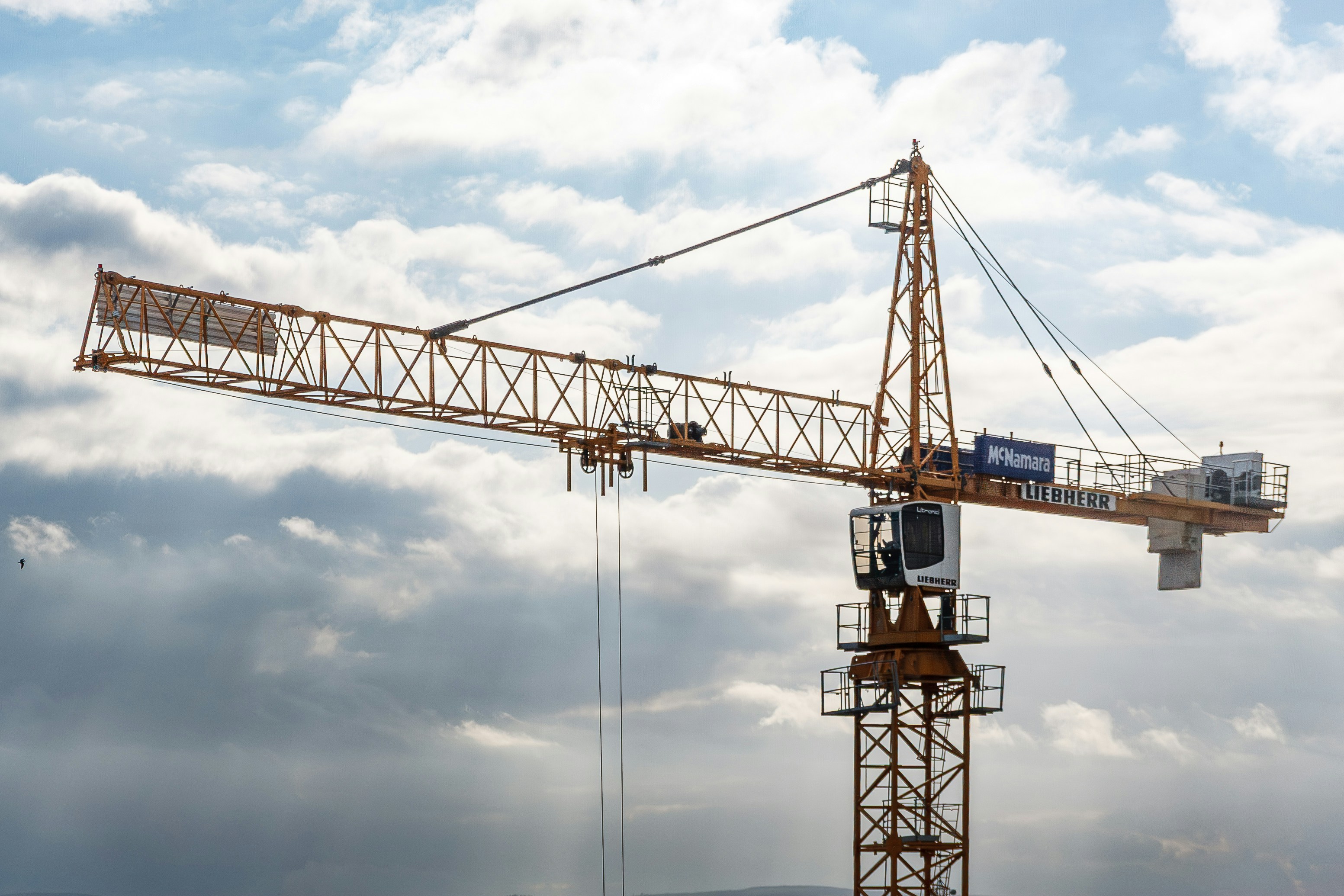Industrial Giant: The Crane Reaches Across a Sky of Turbulent Clouds