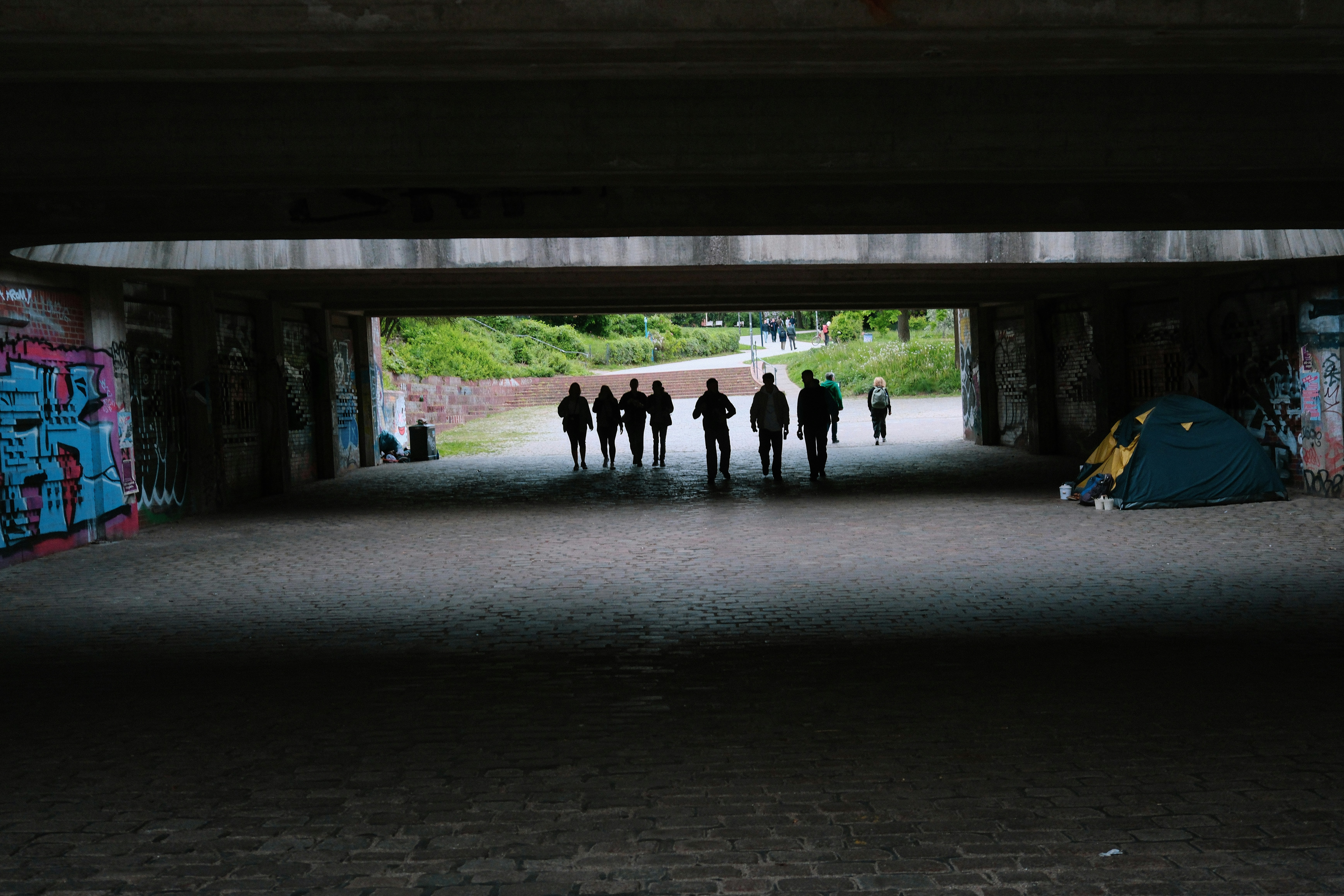 Shadowed Passage: A Line of Wanderers Reaches the Exit