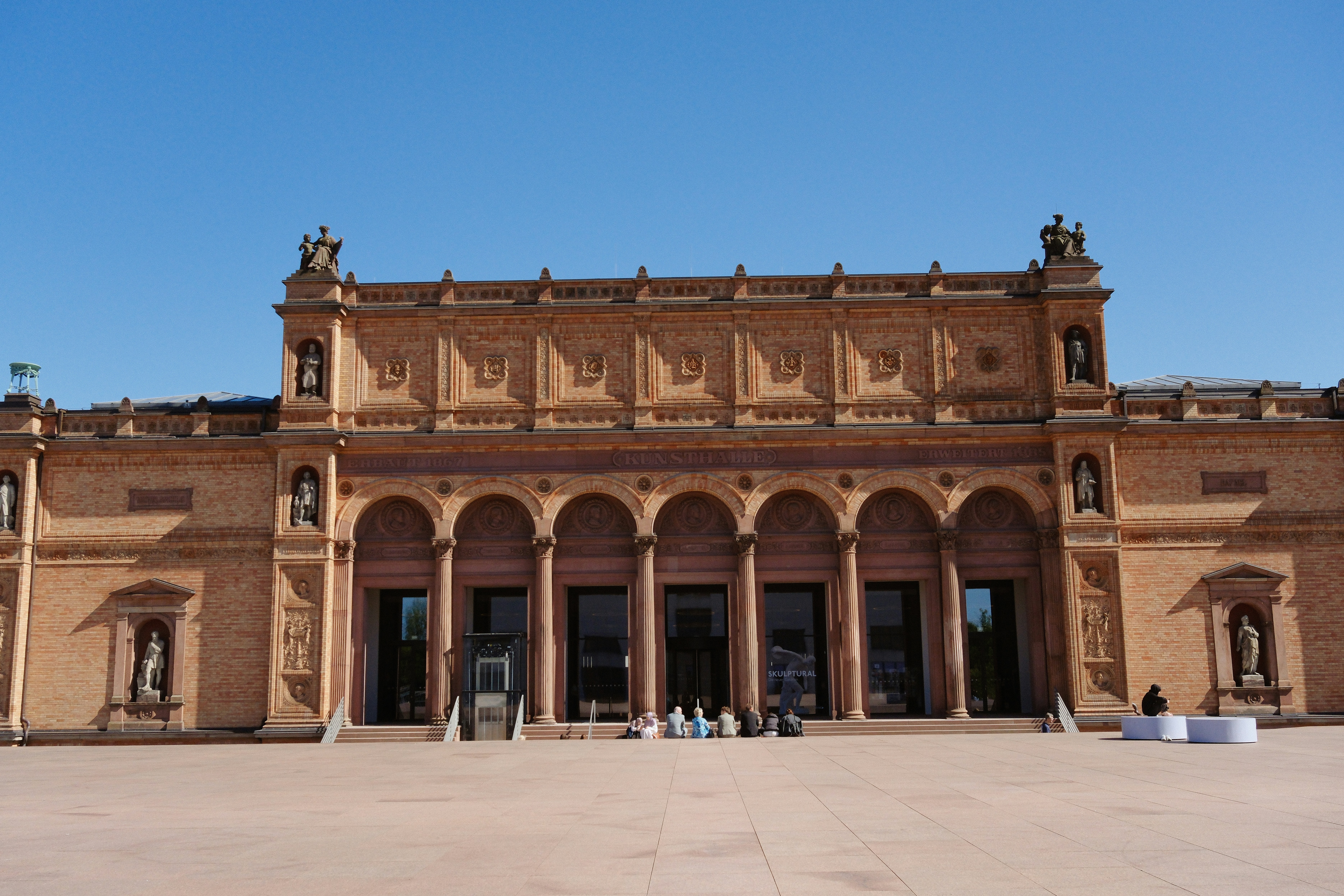 The Grand Arcades: A Brick Facade Under a Clear Harbor Blue