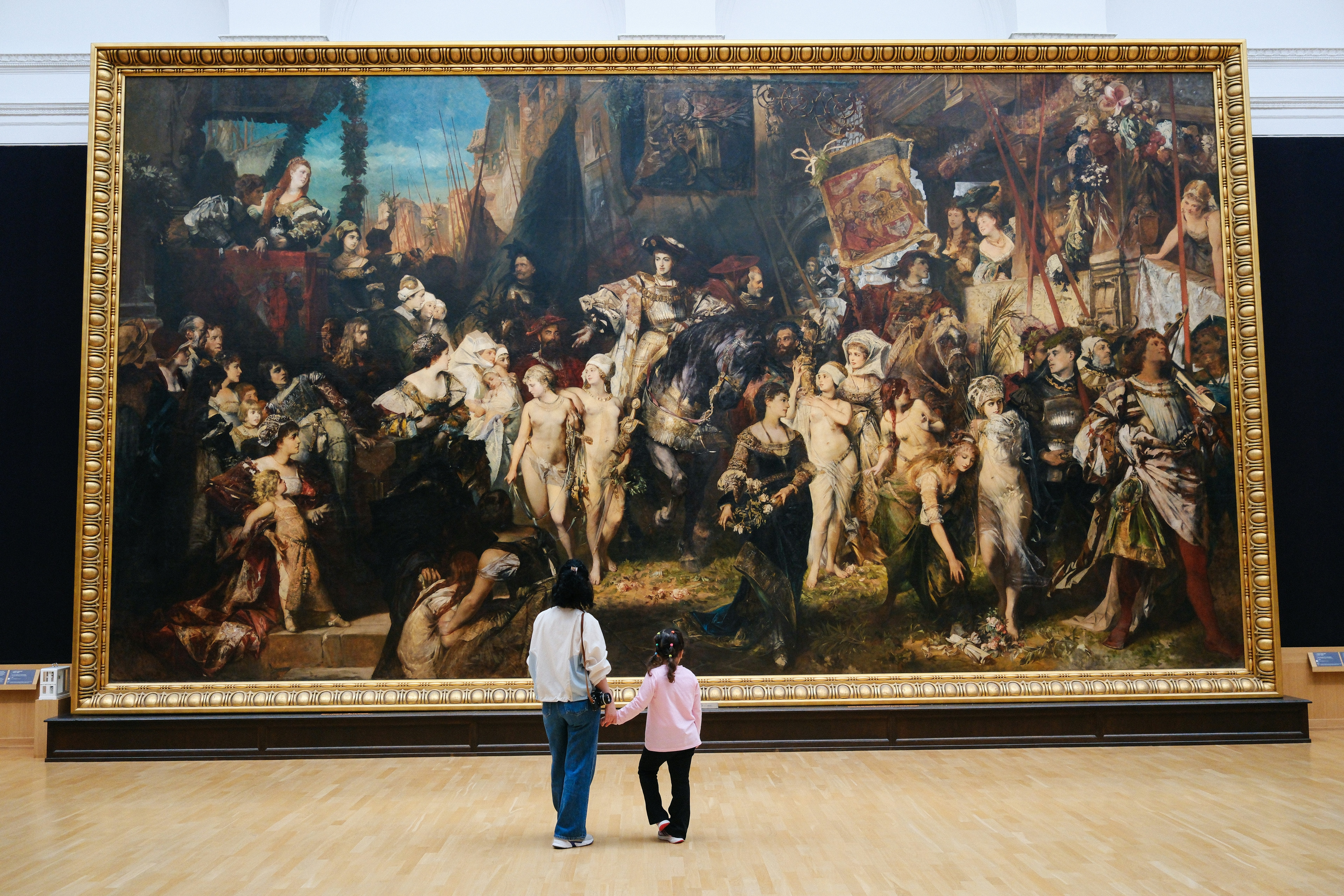 Two visitors at a grand historical painting